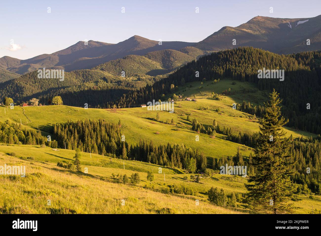 Green meadows with small houses landscape photo Stock Photo - Alamy