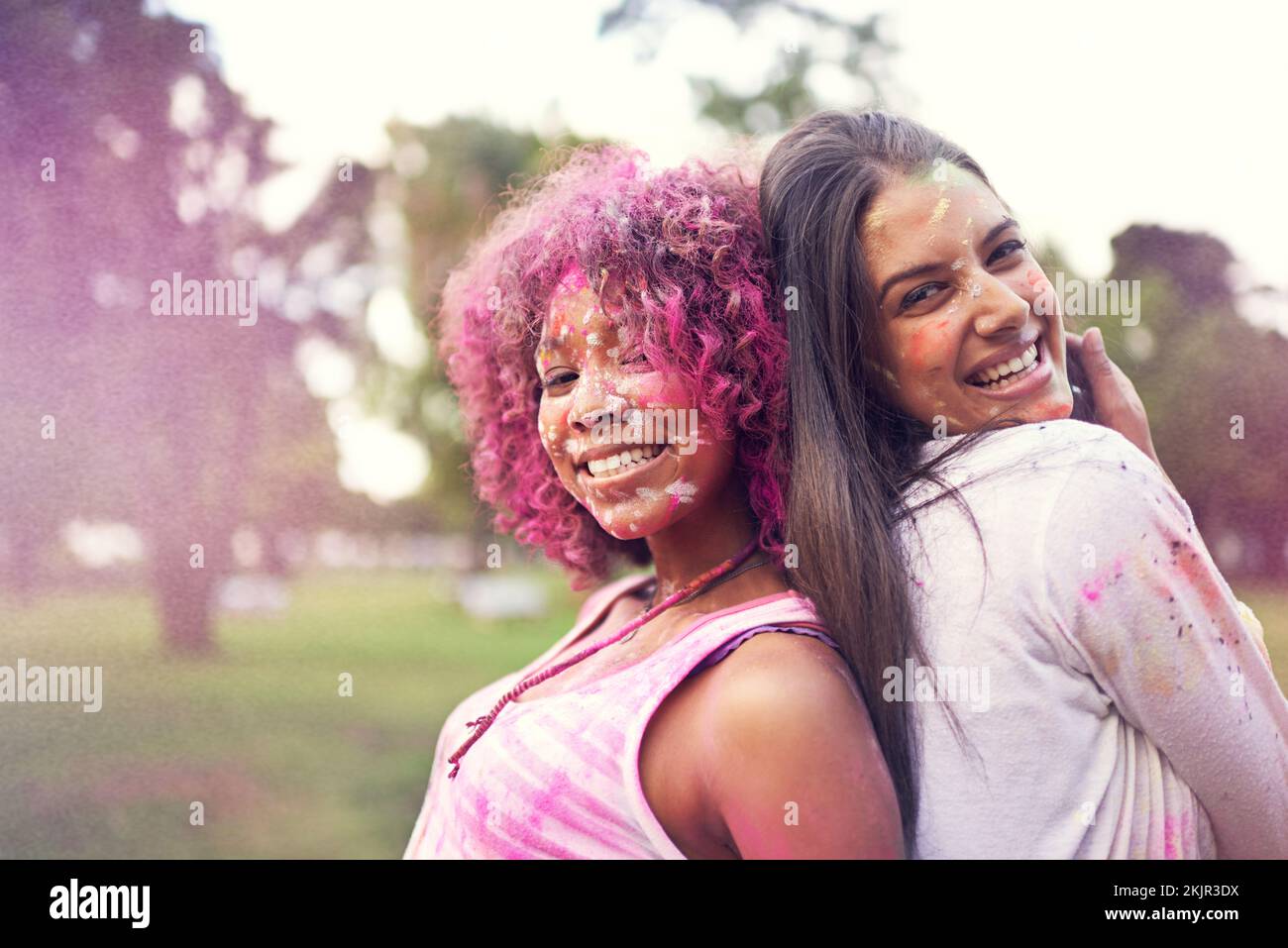 Live in color. Portrait of two friends having fun at a color festival ...