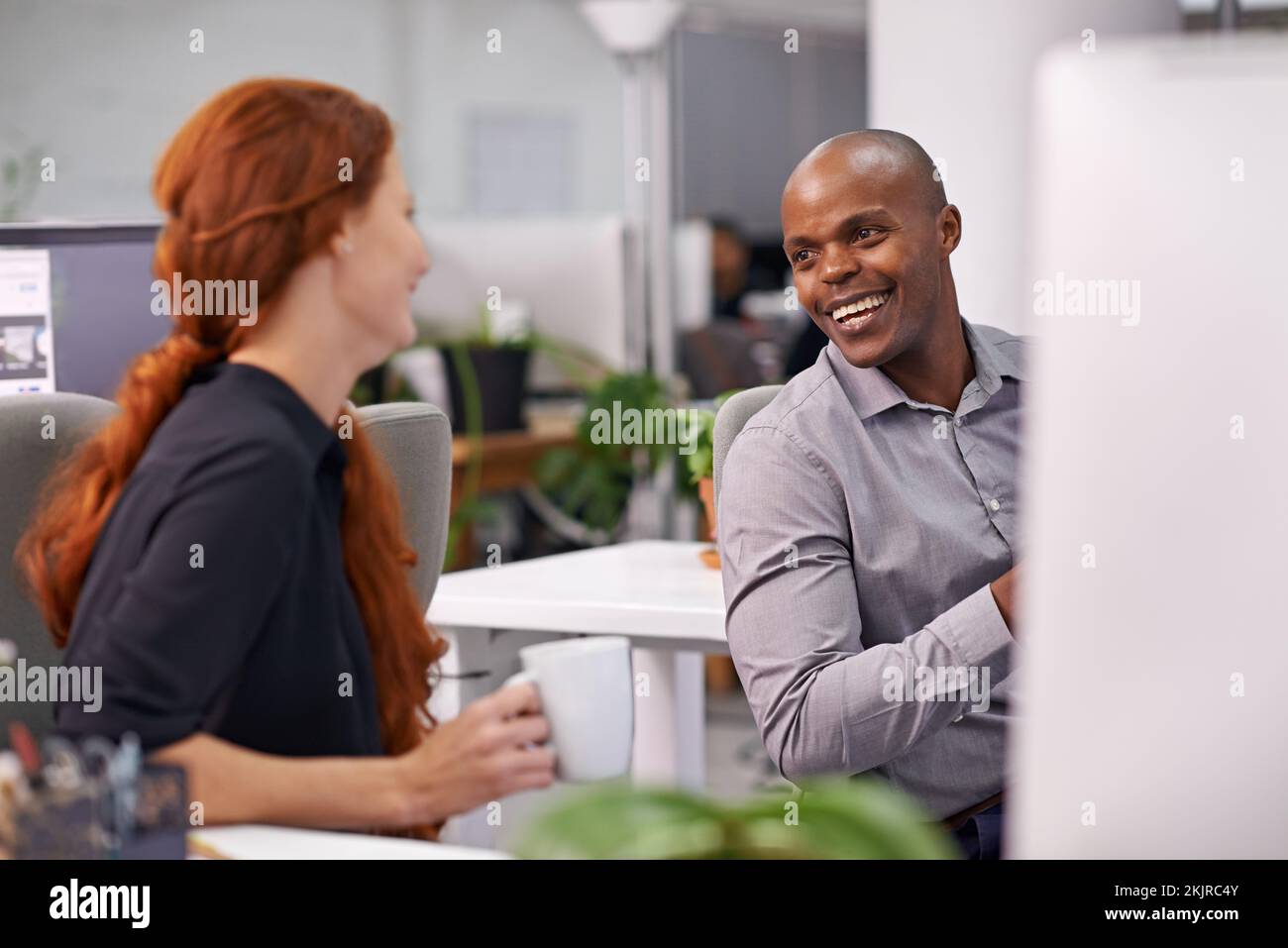 Making friends in the office. Two colleagues sharing a laugh in the ...