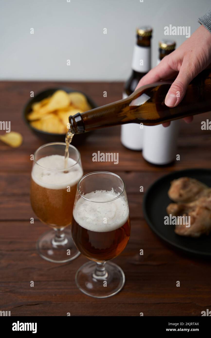 Two glasses with beer, snacks and bottles on wooden table Stock Photo ...