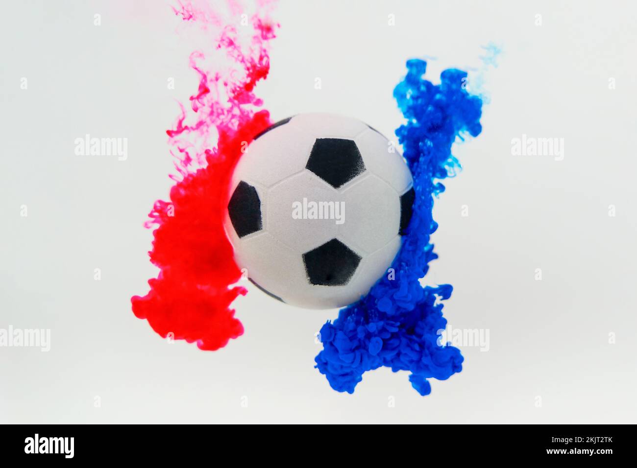 Soccer ball with red and blue color splash on white background. Concept ...