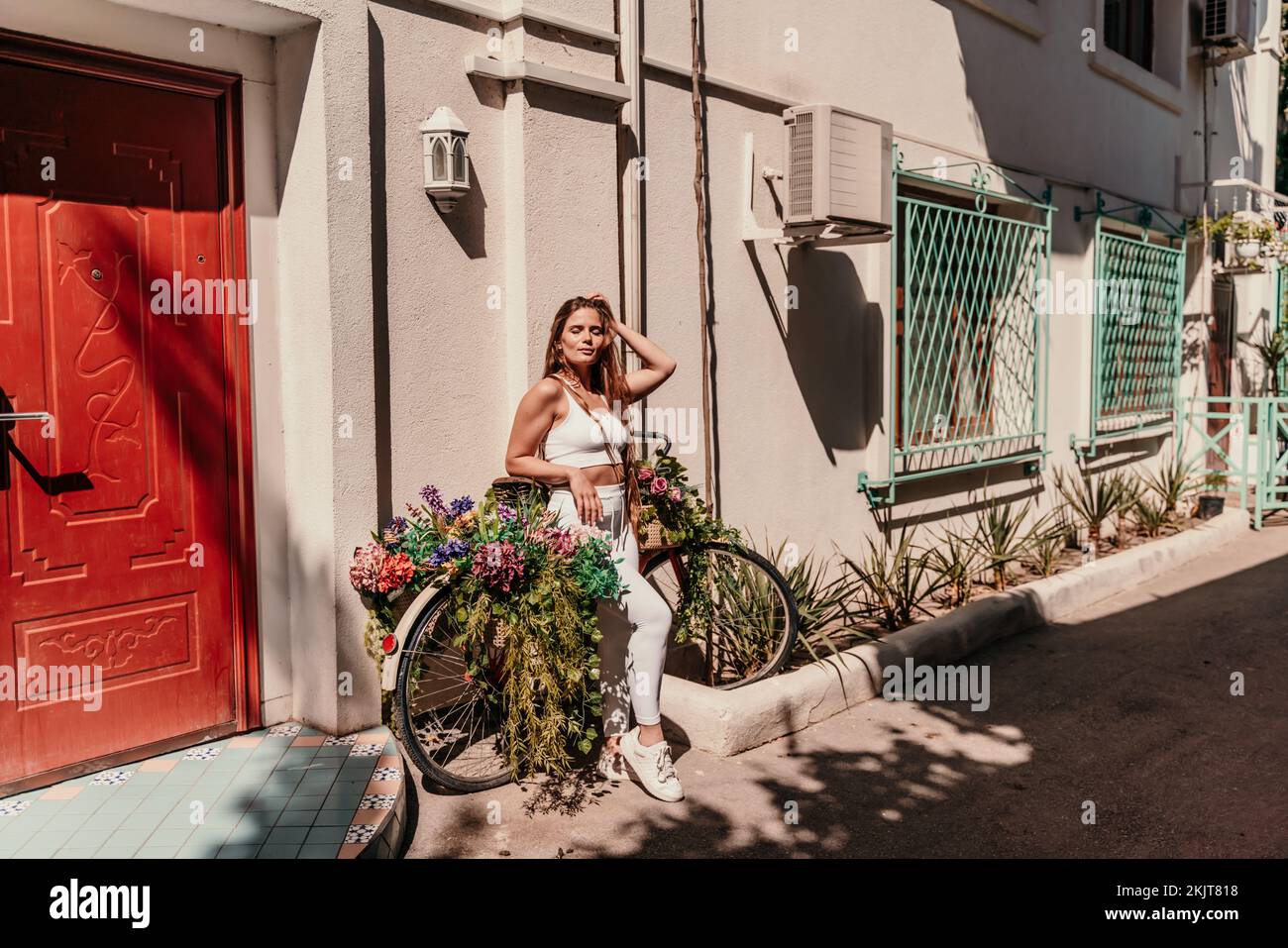 a beautiful girl in a white training suit is going to ride a bike on a ...
