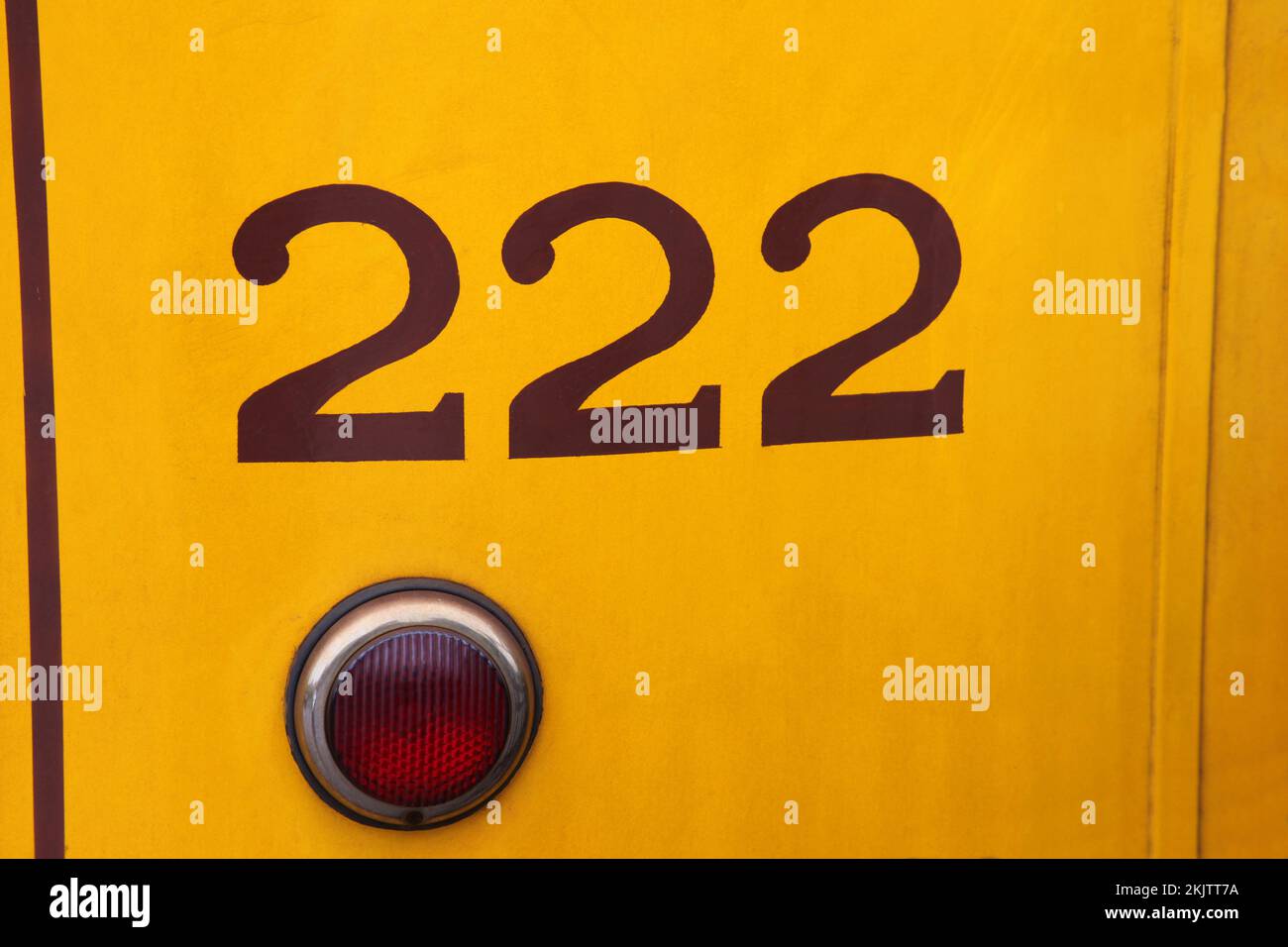 Detail from the rear of a yellow tram showing 222 and a red tail light ...
