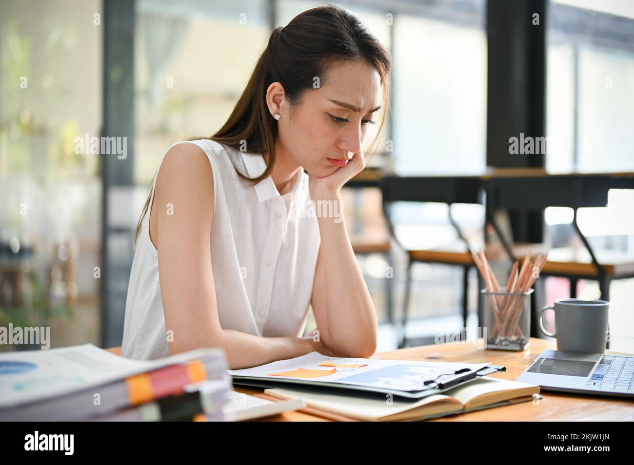 Stressed millennial Asian businesswoman or female manager concentrating ...