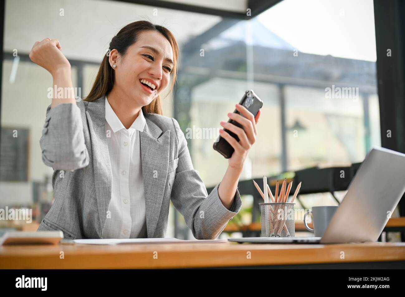 Overjoyed and happy young Asian businesswoman or female marketing ...