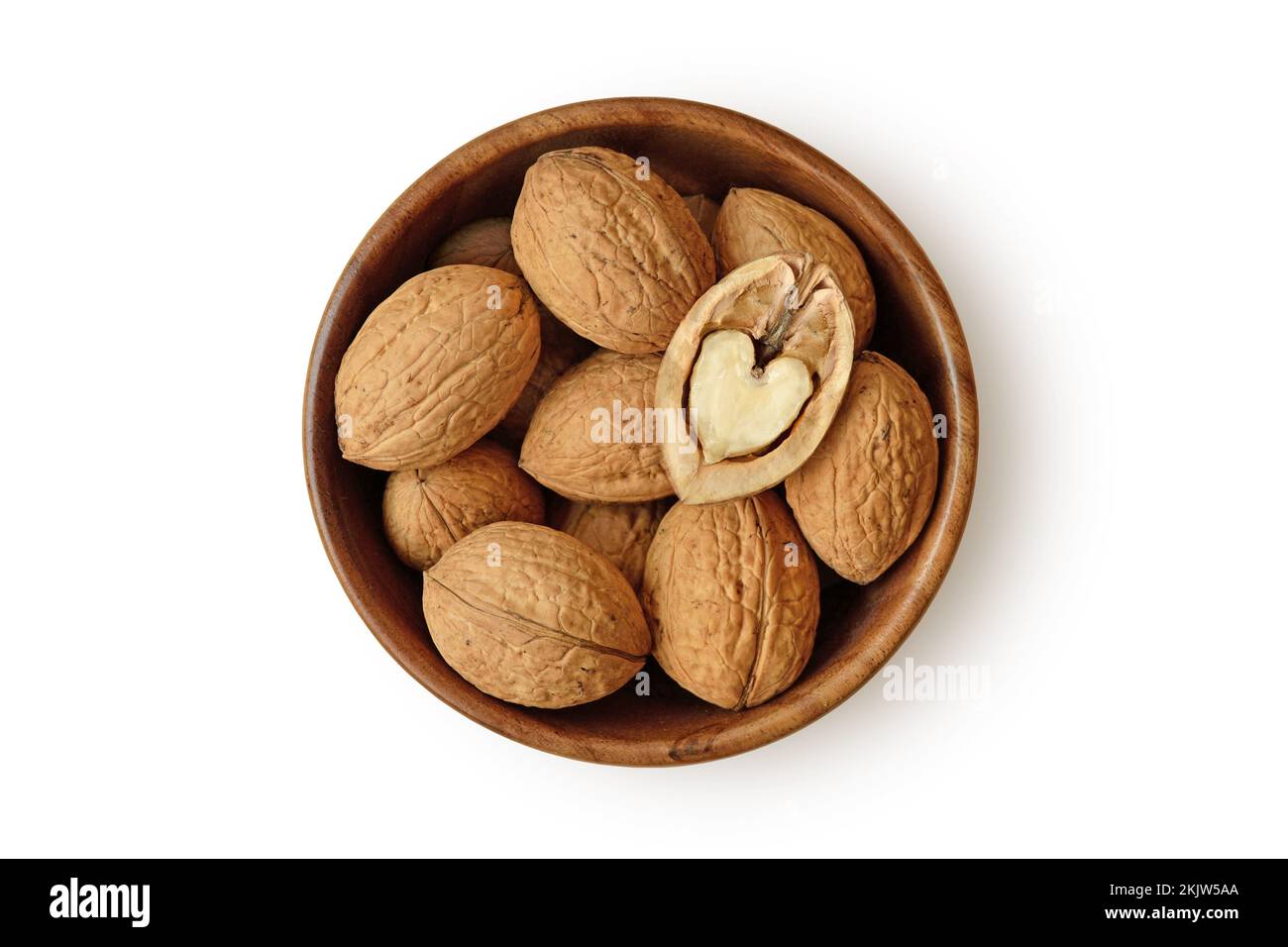 Shelled walnuts with half heart shaped walnut in wooden bowl on white ...