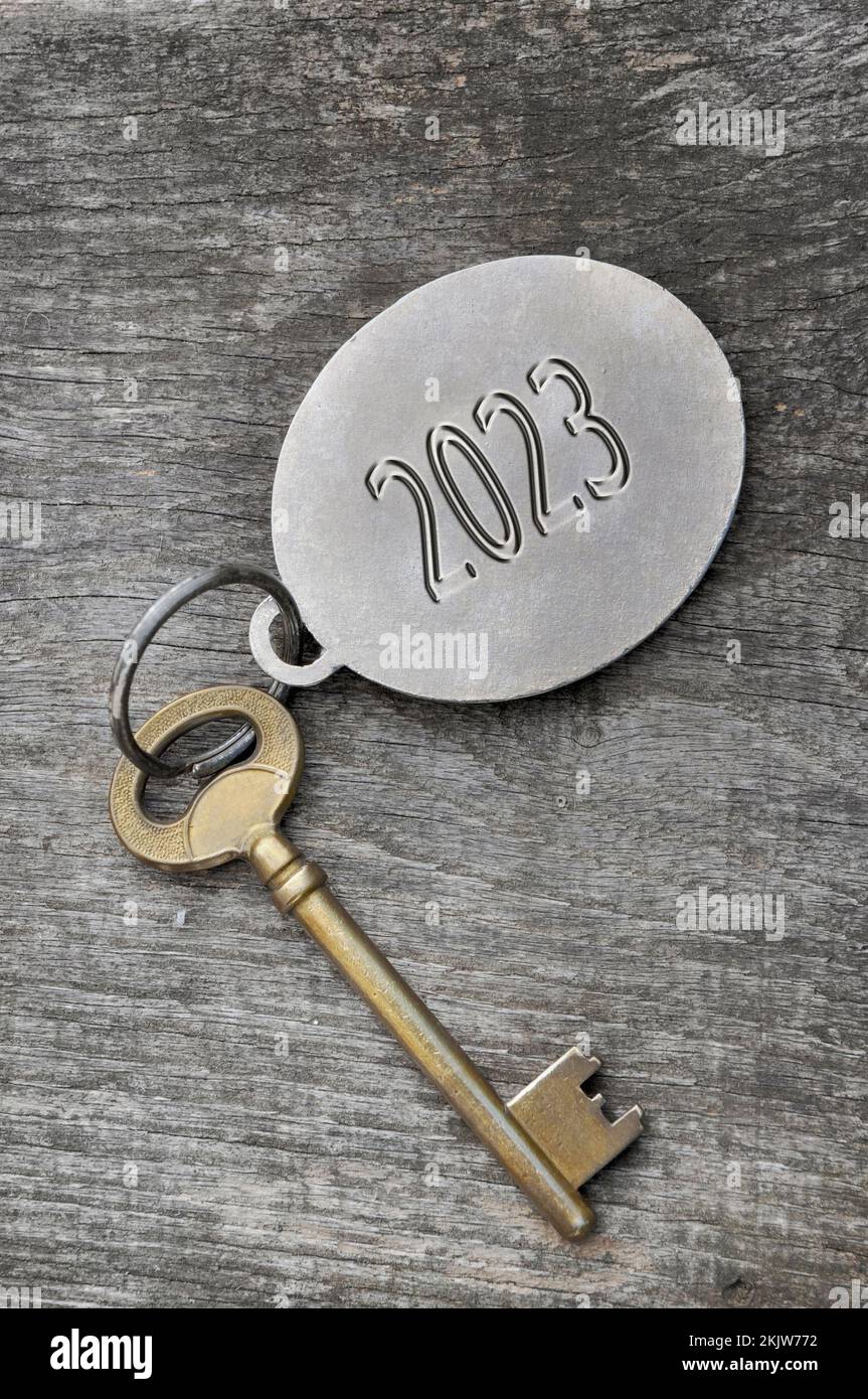 2023 engraved on a ring of an old golden key on rustic wooden Stock ...