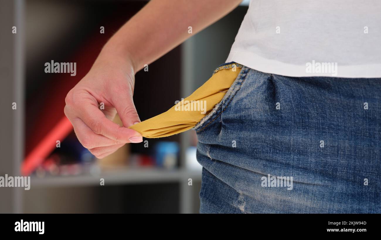 Woman turning inside and showing empty jeans pocket Stock Photo - Alamy