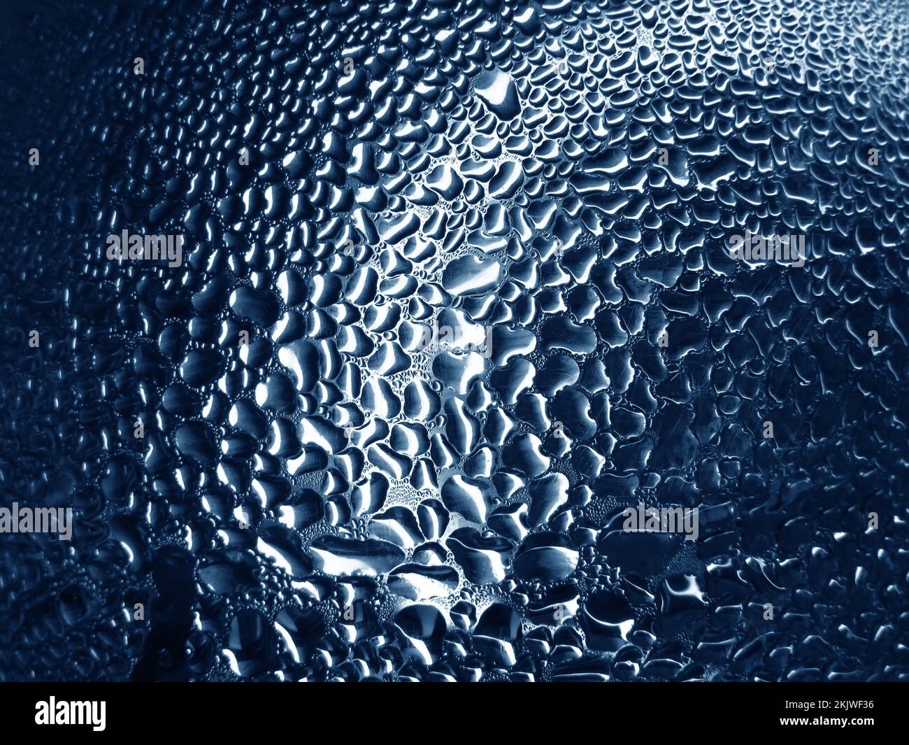 Glass with raindrops on blue tone background. Abstract ultramarine wet ...