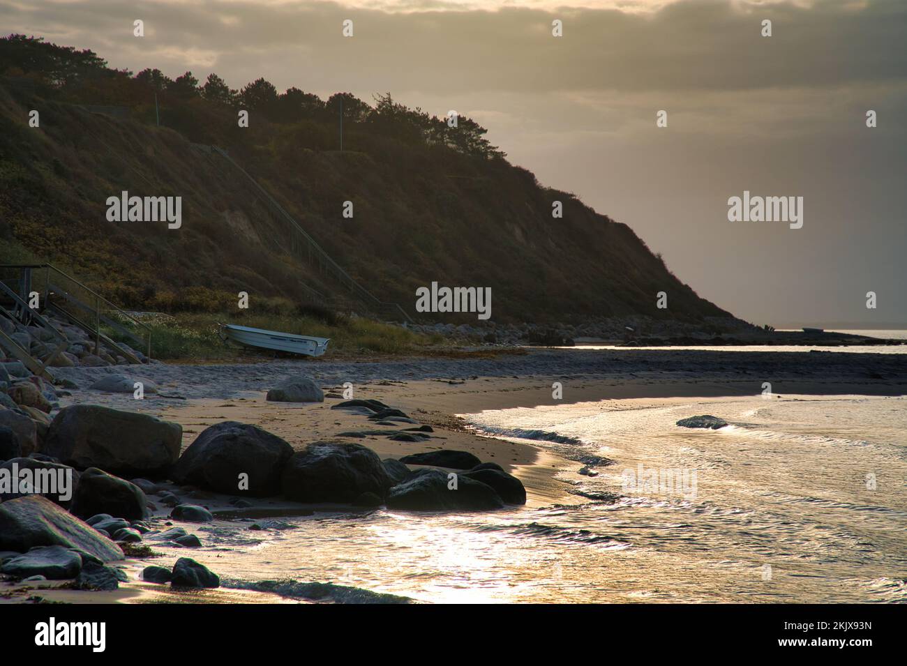 Sunset on the Danish coast. Beach, waves. Hill with trees in background ...