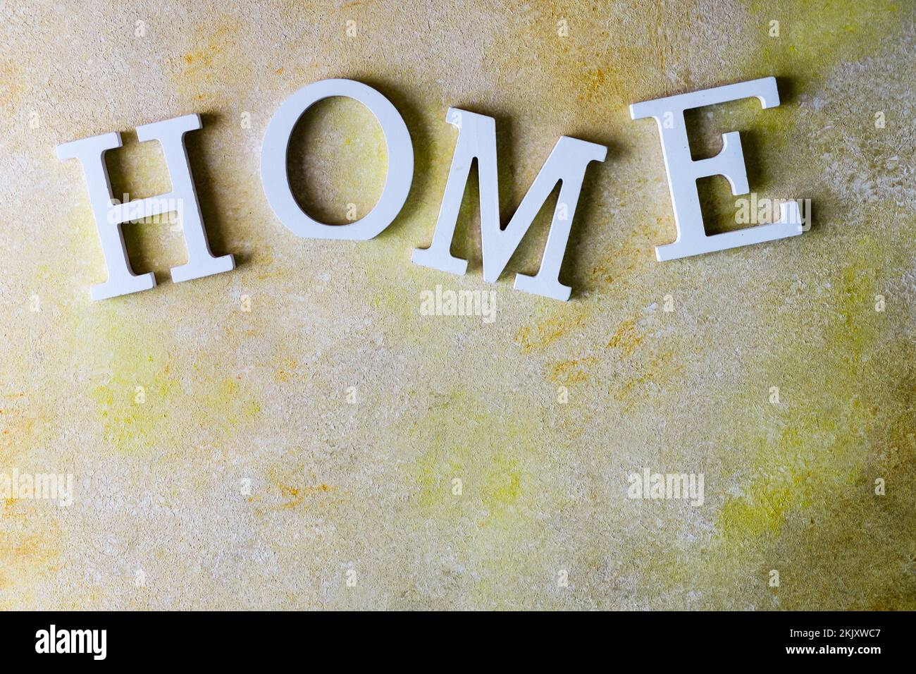 A concrete wall with the hanging text HOME Stock Photo - Alamy