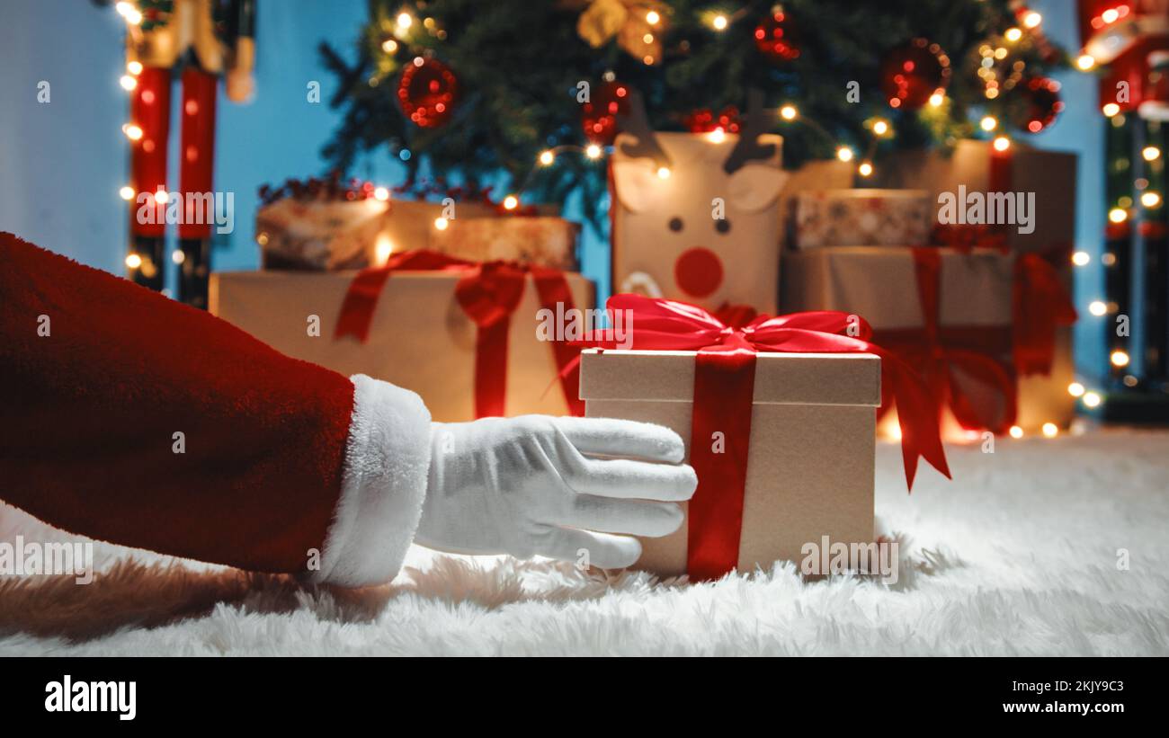 Santa claus hand with Christmas gift box Stock Photo - Alamy