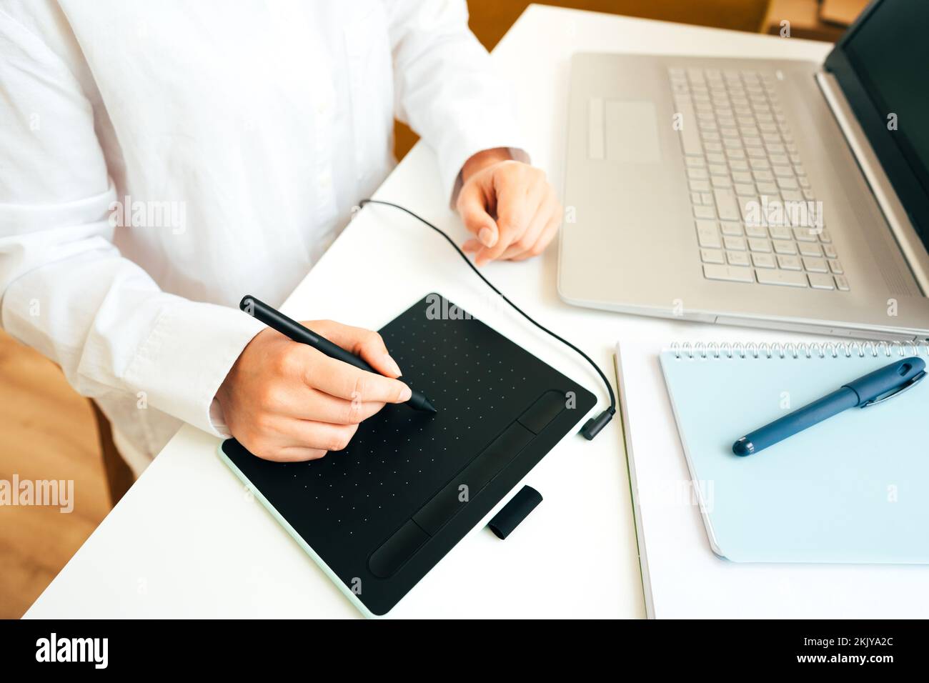 Young woman graphic designer hands - using laptop computer and graphic ...