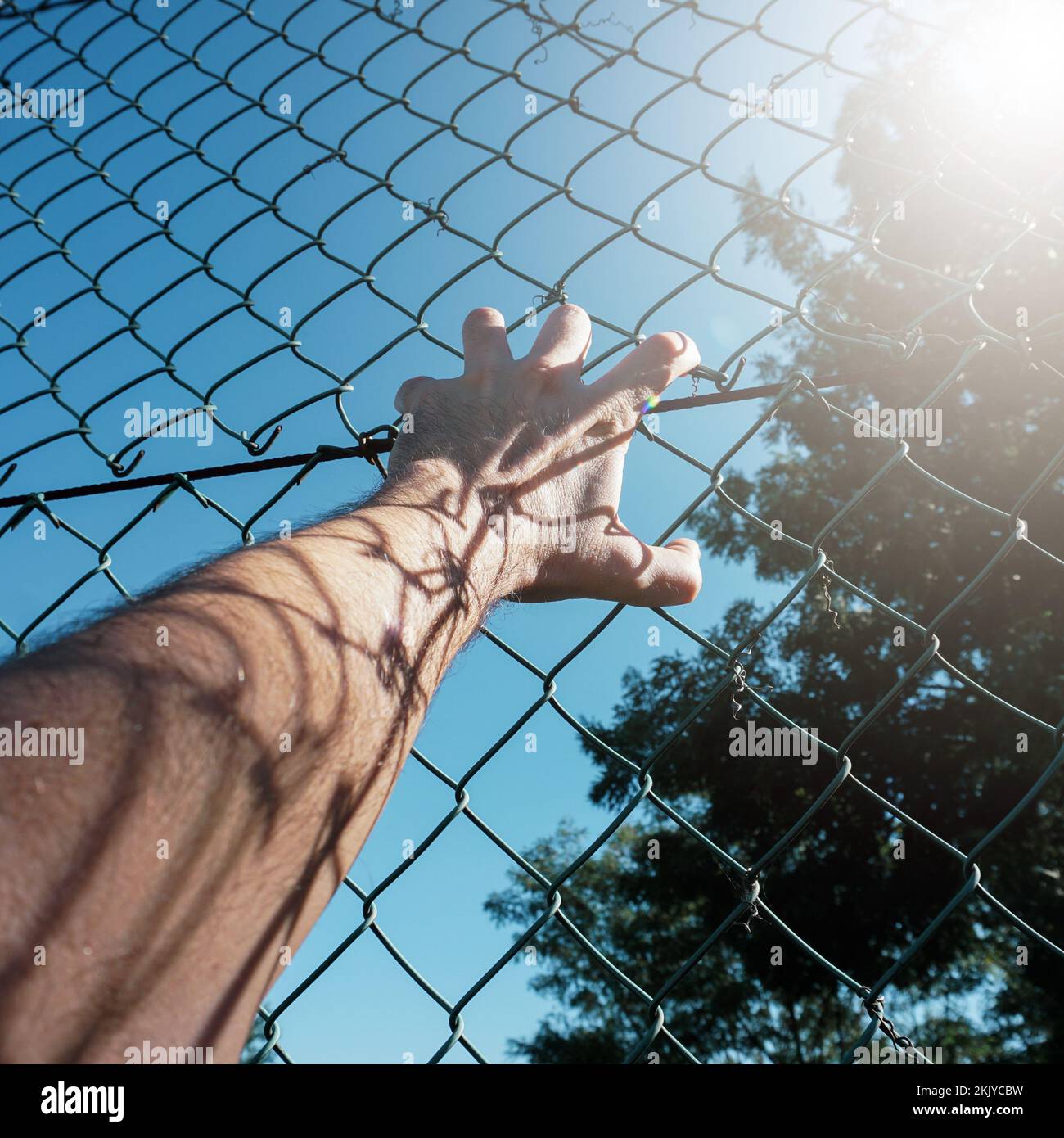 hand grabbing a metallic fence Stock Photo - Alamy
