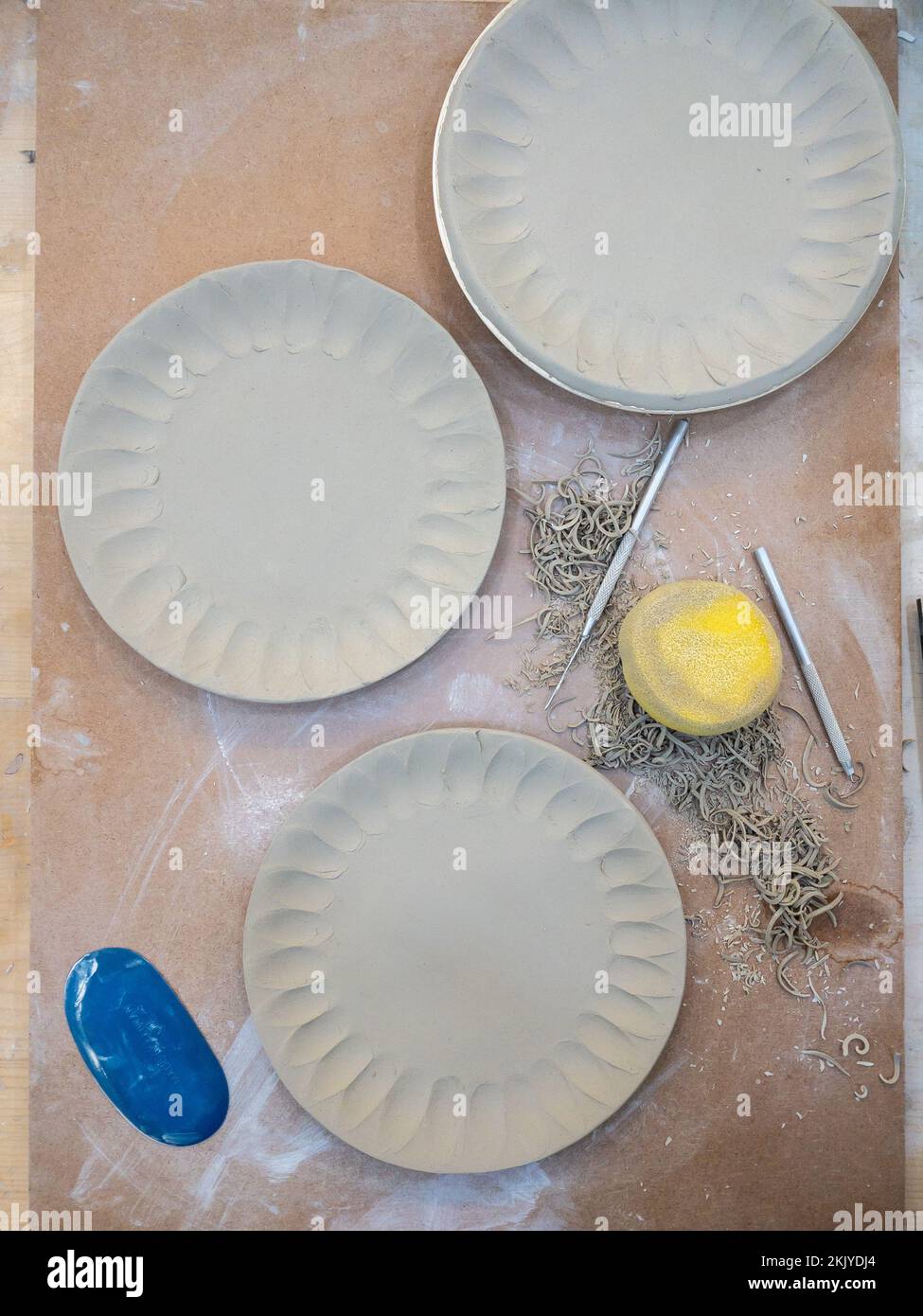 3 Ceramic plates in bisque moulds with pottery tools and sponge Stock ...