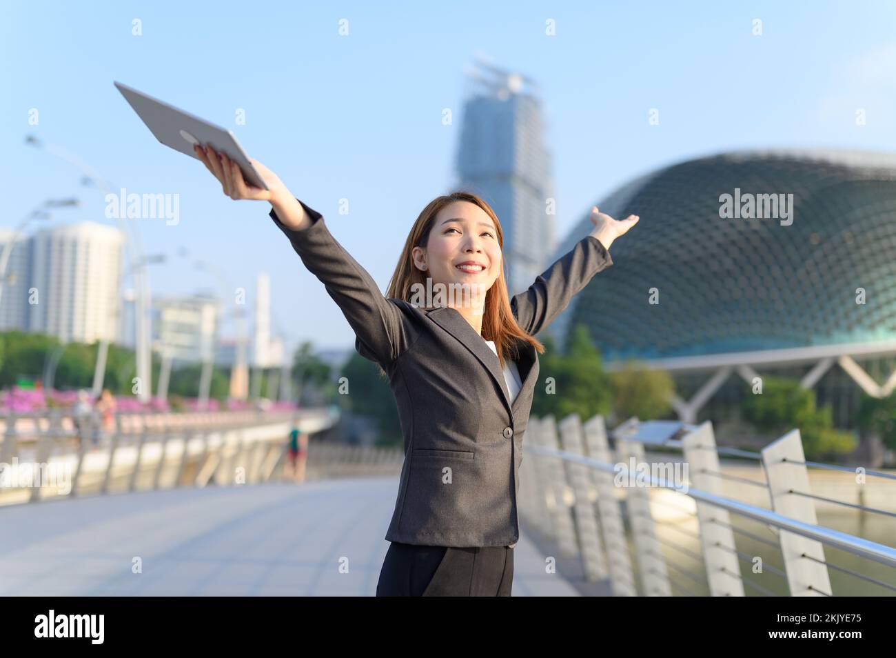 Happy Asian business woman with hands raised high for successfully done ...