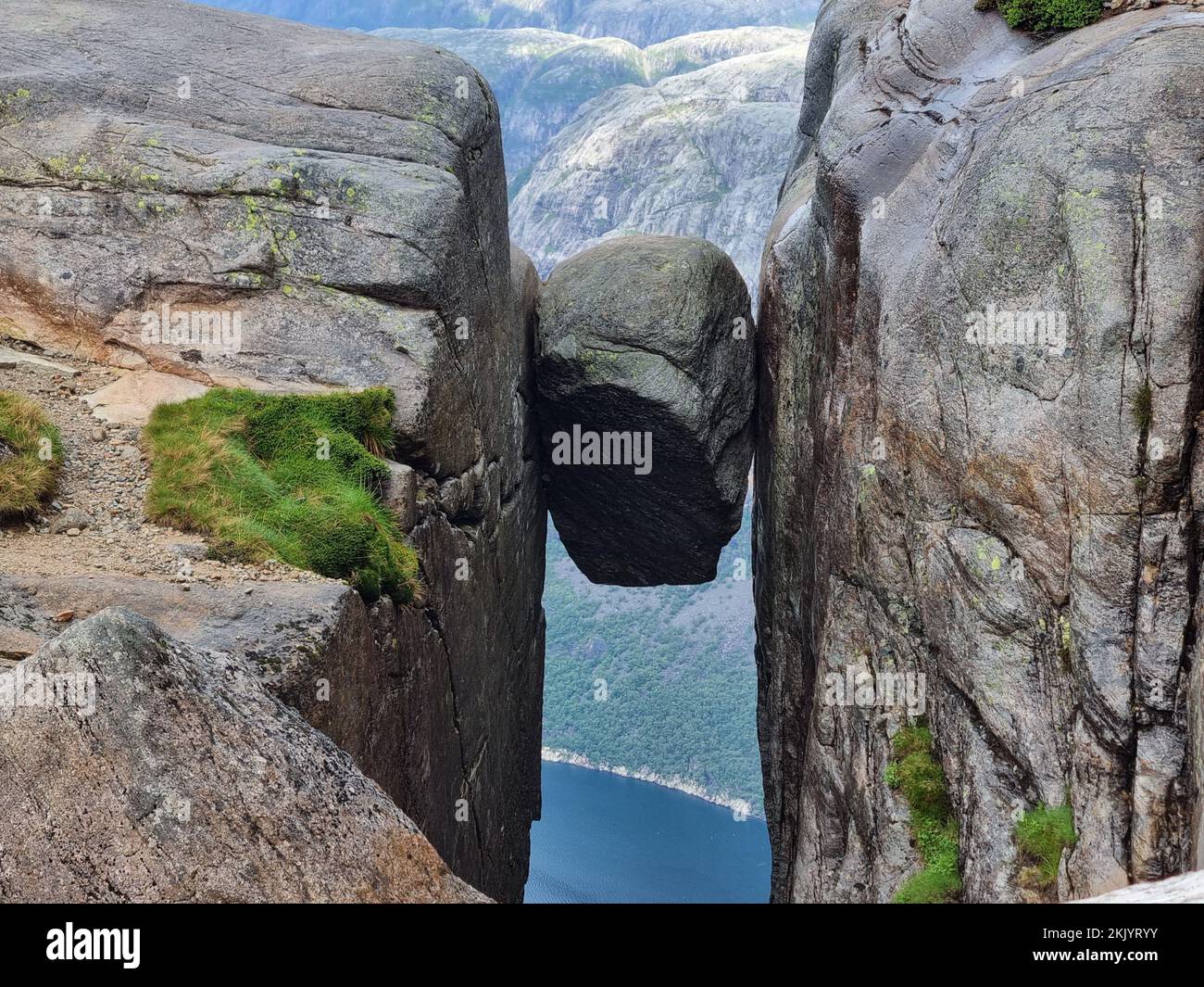 A stone stuck between two rocks on a cloudy day Stock Photo - Alamy
