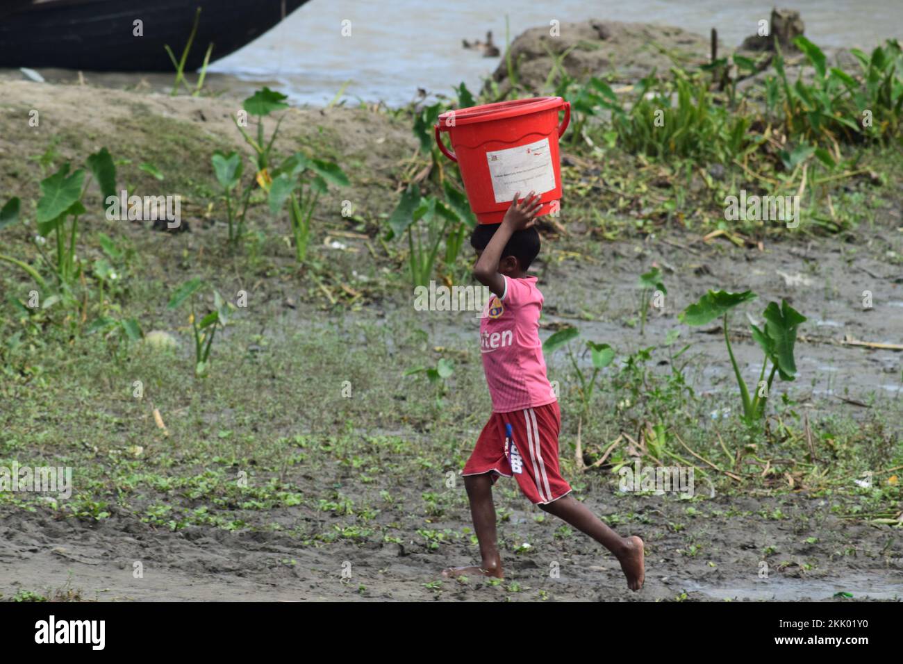 Coastal fisherman's kid bringing bucket to collect fish Stock Photo - Alamy