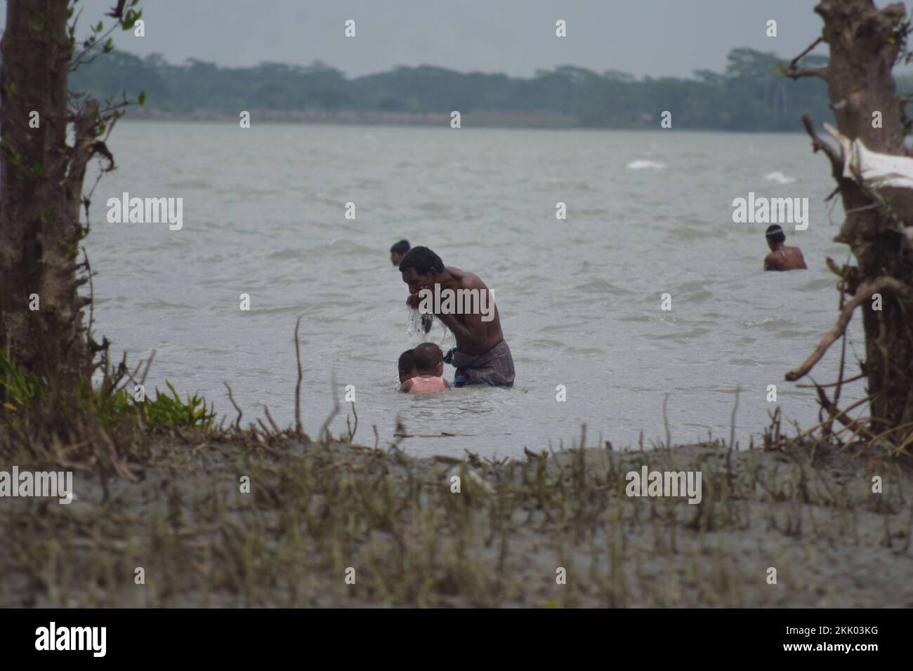Coastal father is taking a bath with his kid in the river Stock Photo ...
