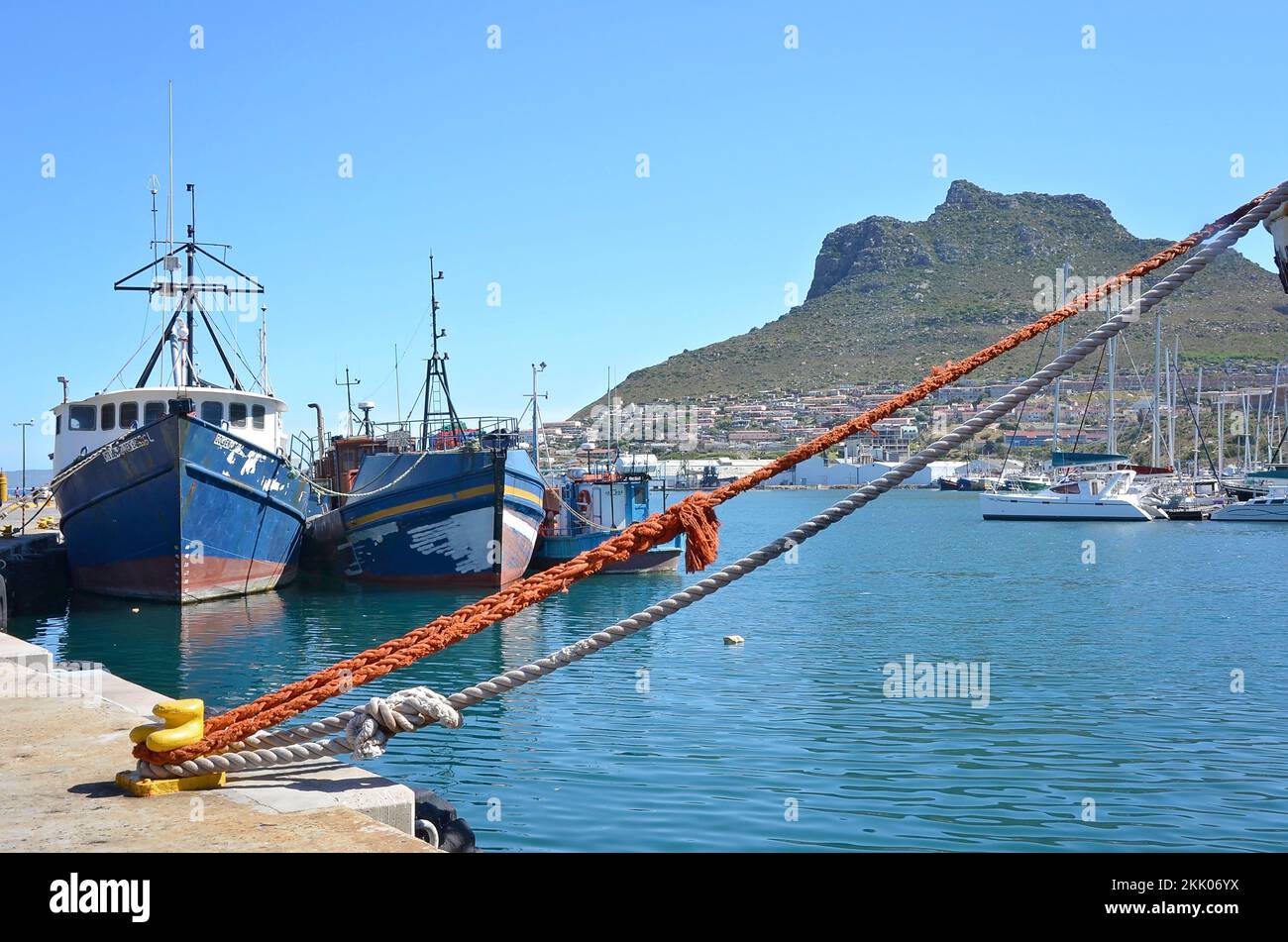 A mooring red rope and fishing trawlers in a harbor on a sunny day ...