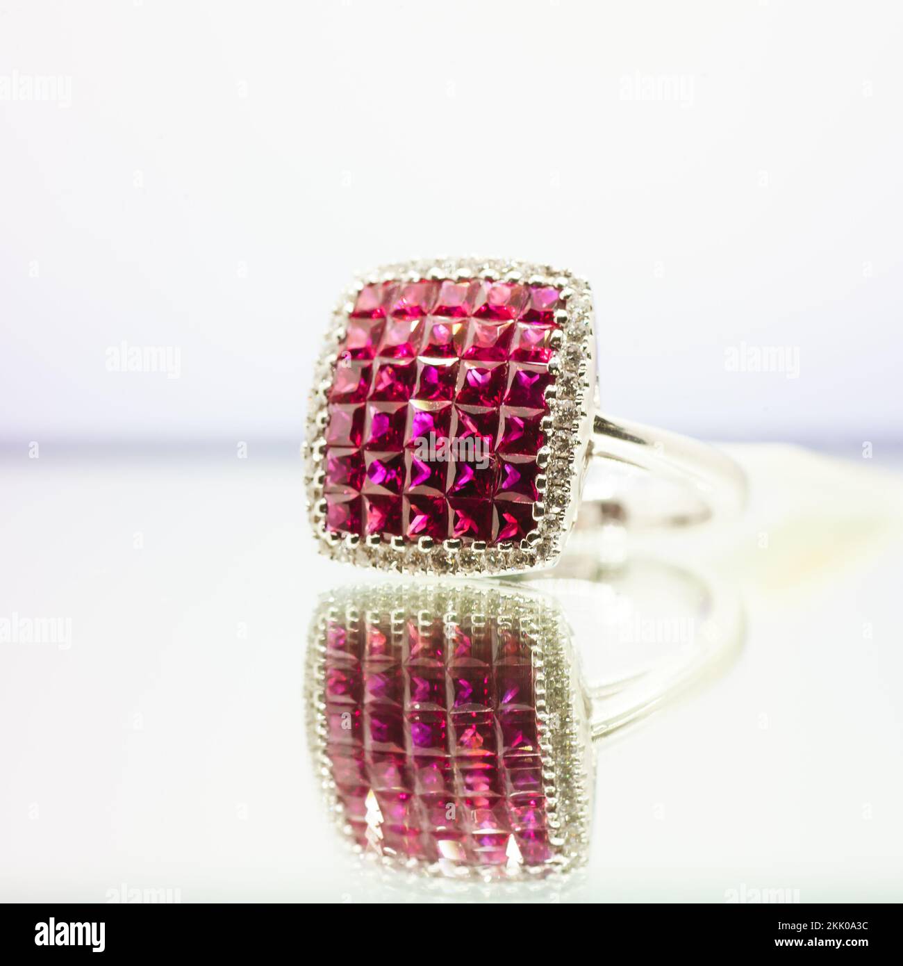 Engagement diamond ring on a mirror surface. emeralds, sapphires, and ...