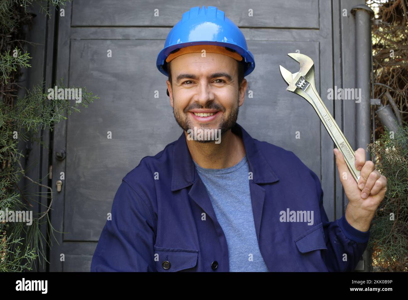 Maintenance worker holding large adjustable wrench Stock Photo - Alamy