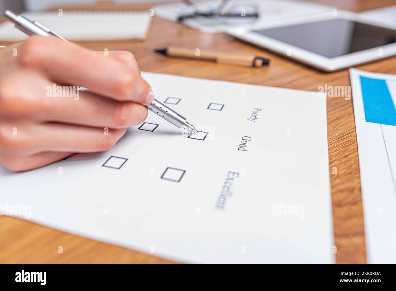 A woman's hand fills out a checklist or an exam test giving a mark of ...