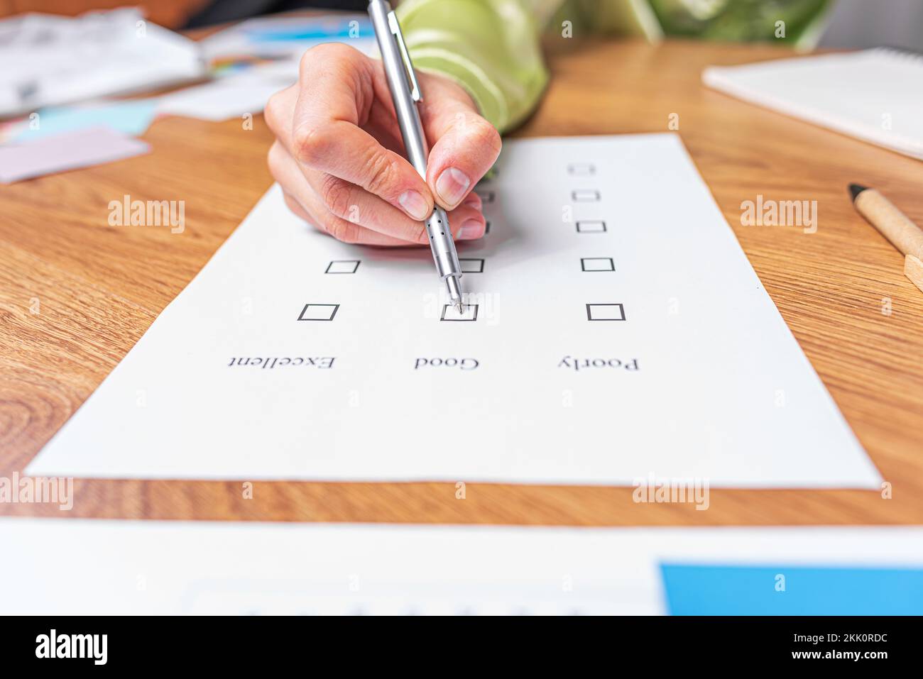 A woman's hand fills out a checklist or an exam test giving a mark of ...