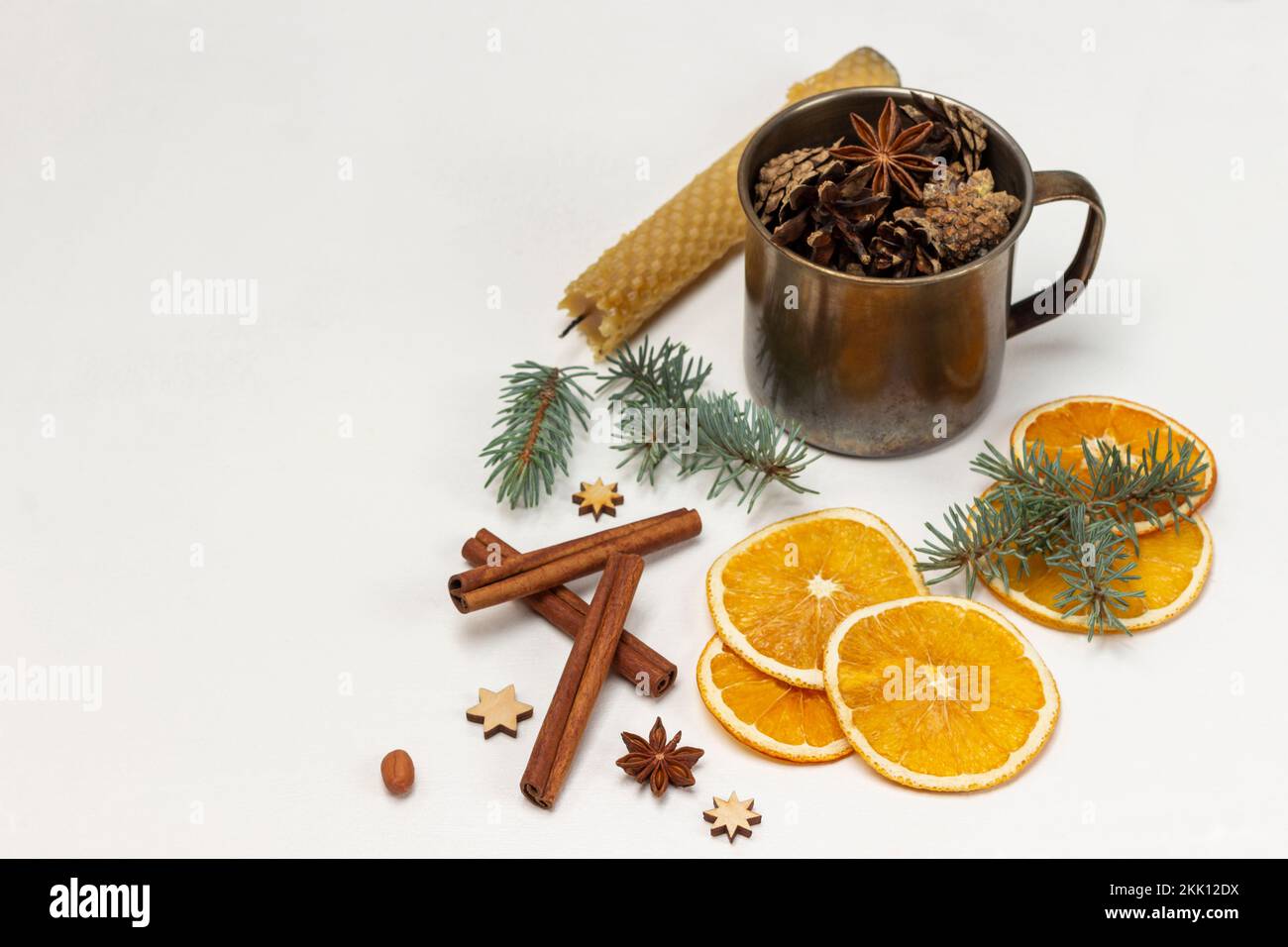 Christmas decorations. Cones in metal mug, candle, cinnamon sticks ...