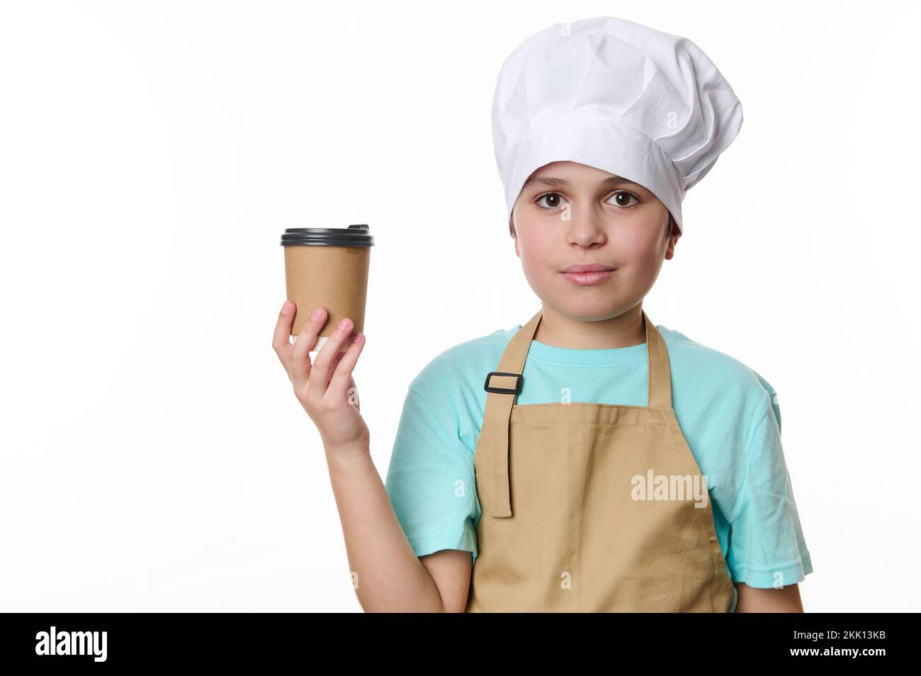 Adorable teenage boy in white chef's hat and beige apron, with a ...