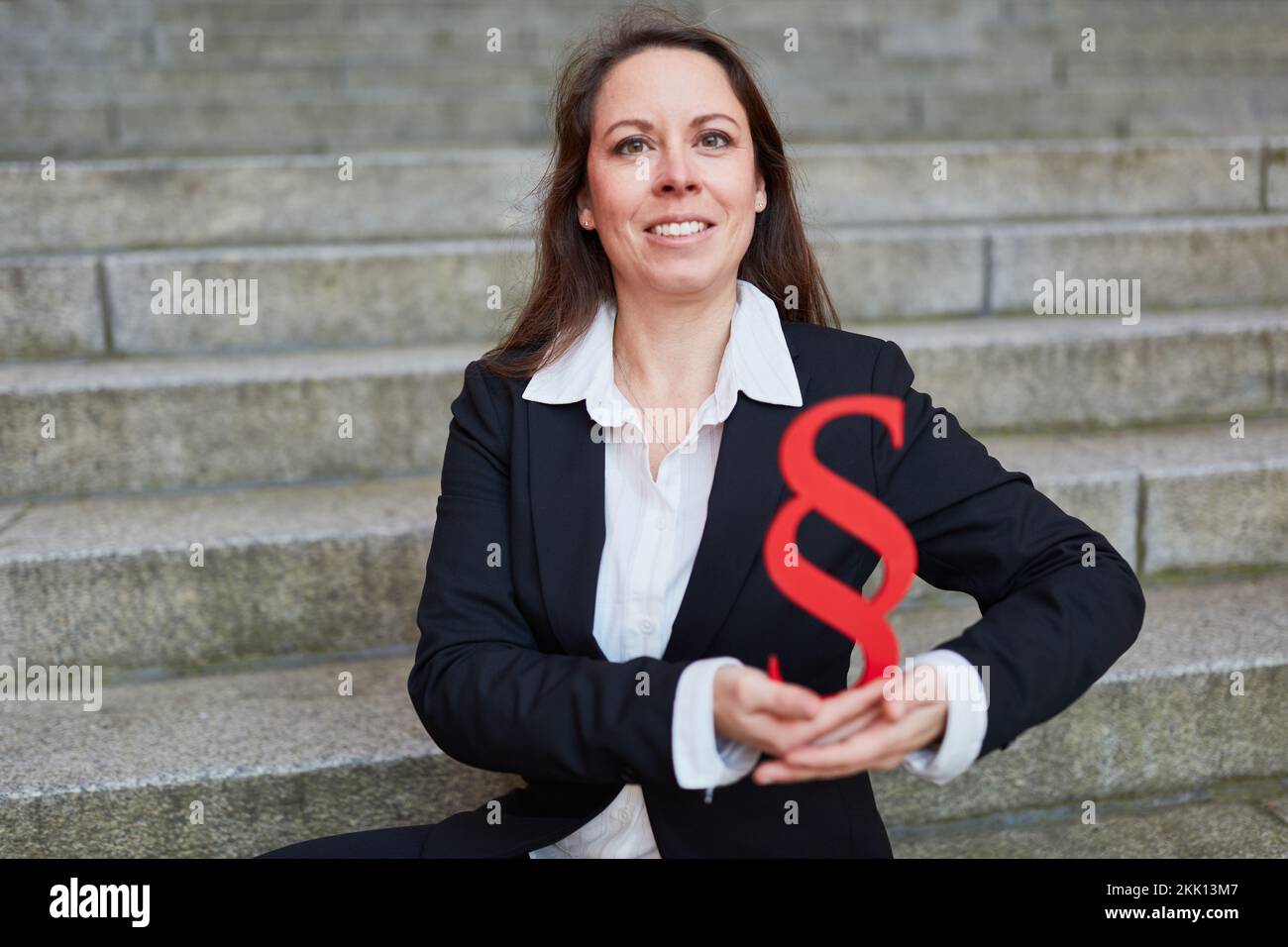 Happy female lawyer holding big red paragraph sign as justice and law ...