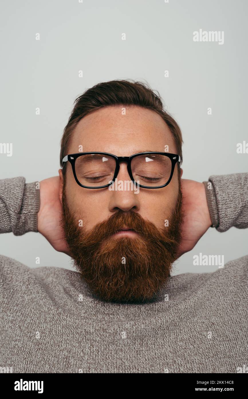 Portrait of bearded man in eyeglasses touching back of head isolated on ...
