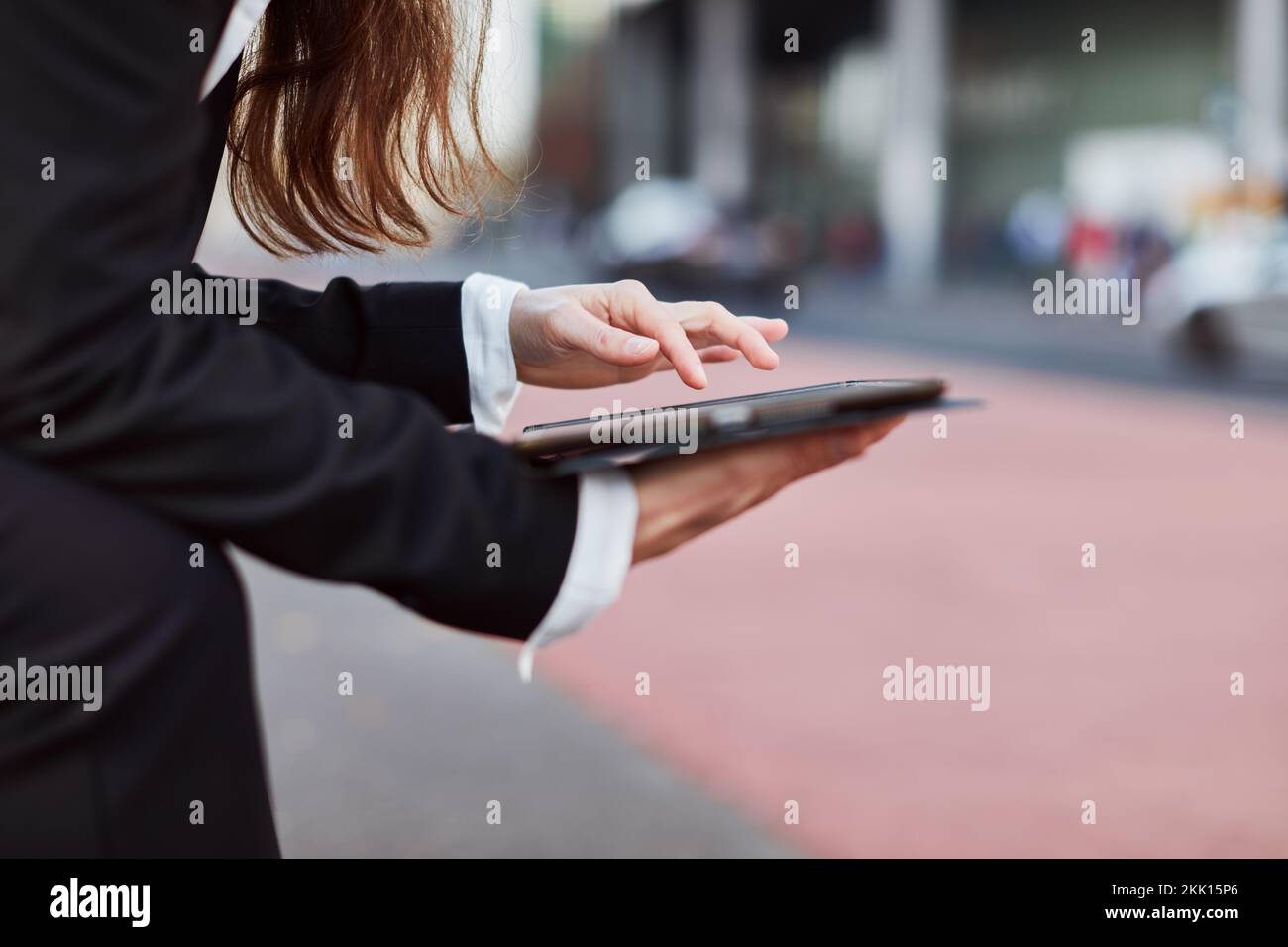 Hand Businesswoman using touchscreen of tablet computer outside in the ...