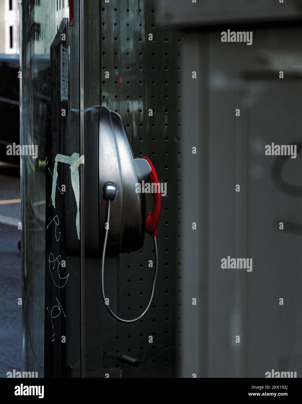 Telephone box in the city centre of Bern. With a glowing red telephone ...