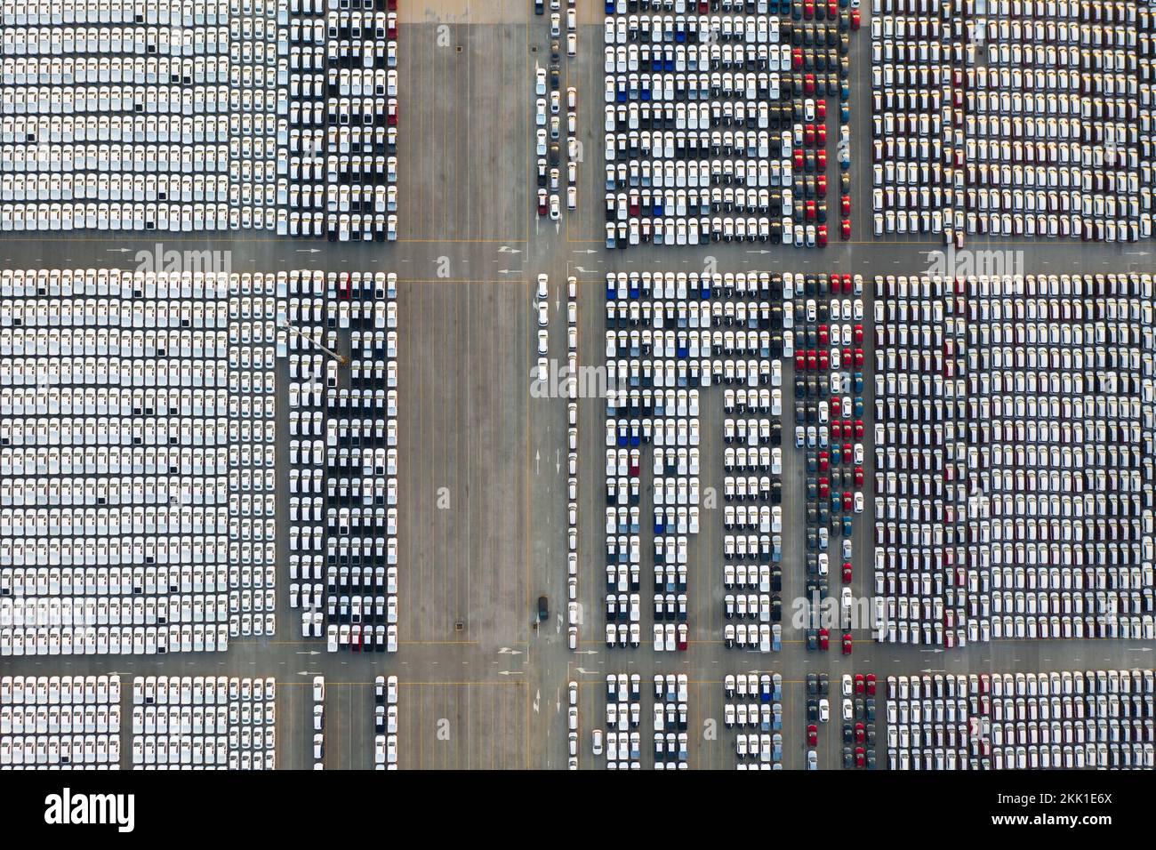 An aerial shot of rows of new cars in a logistic port export terminal ...