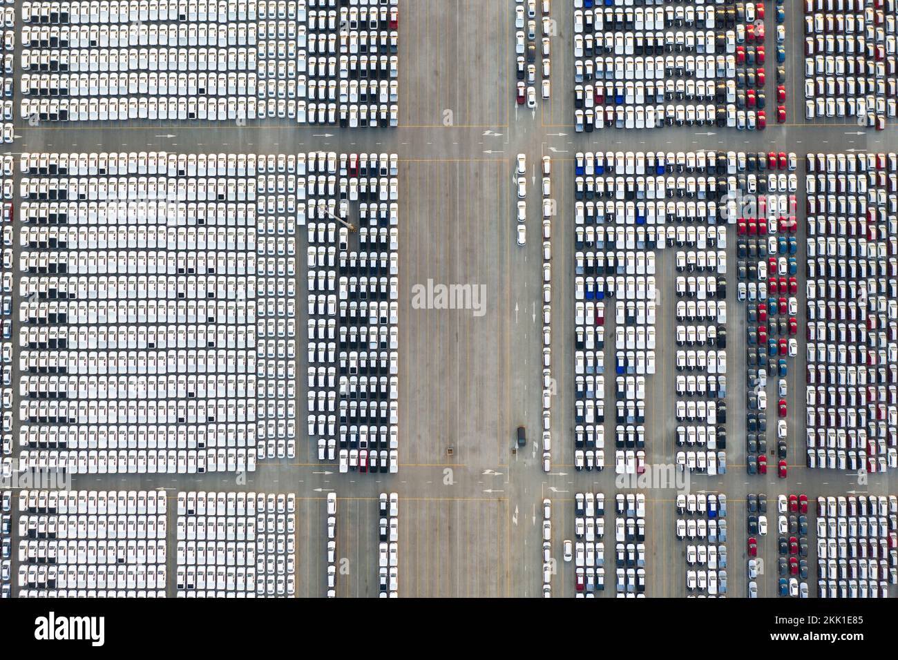 An aerial shot of rows of new cars in a logistic port export terminal ...