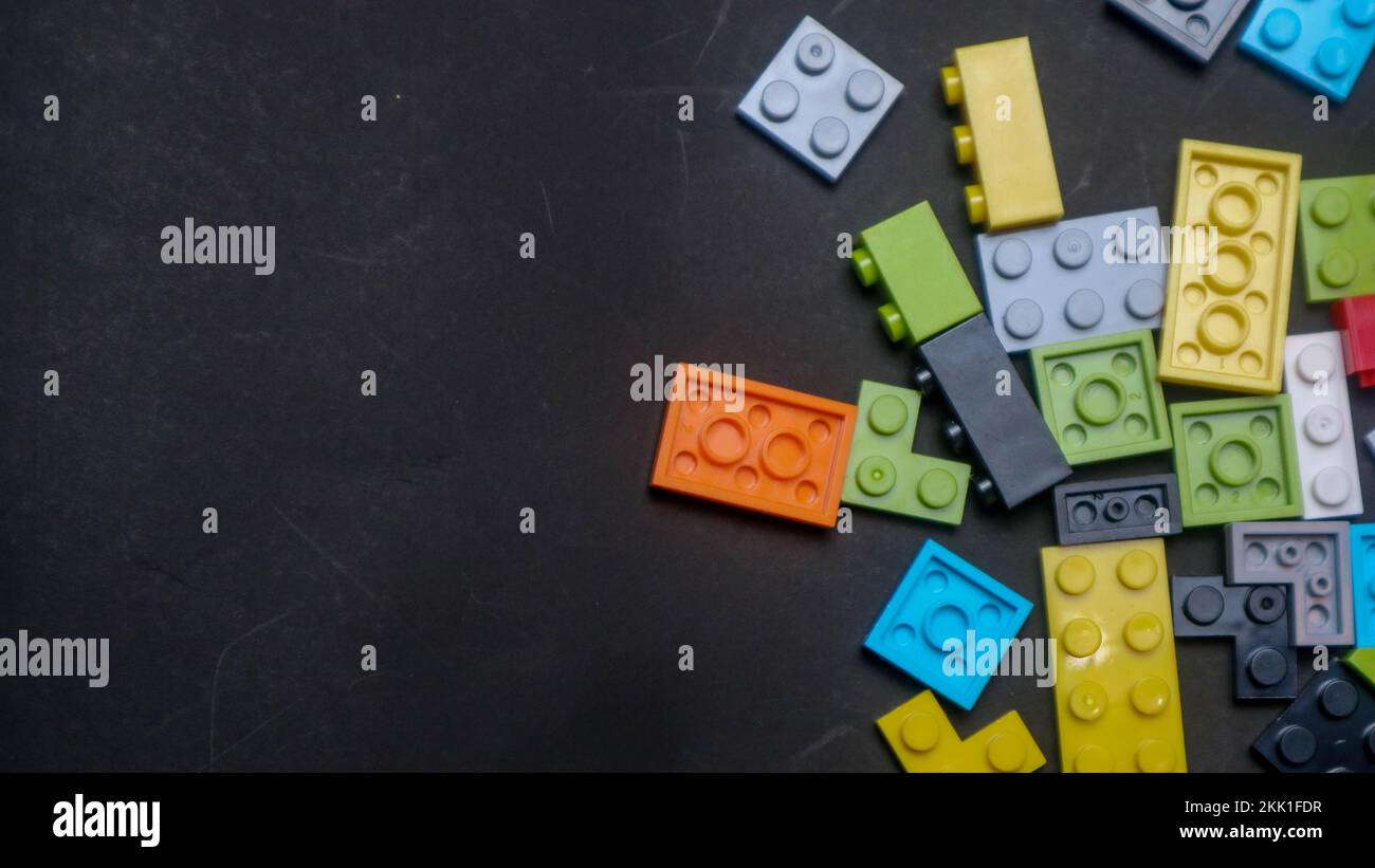 Plastic toy blocks on black background Stock Photo - Alamy