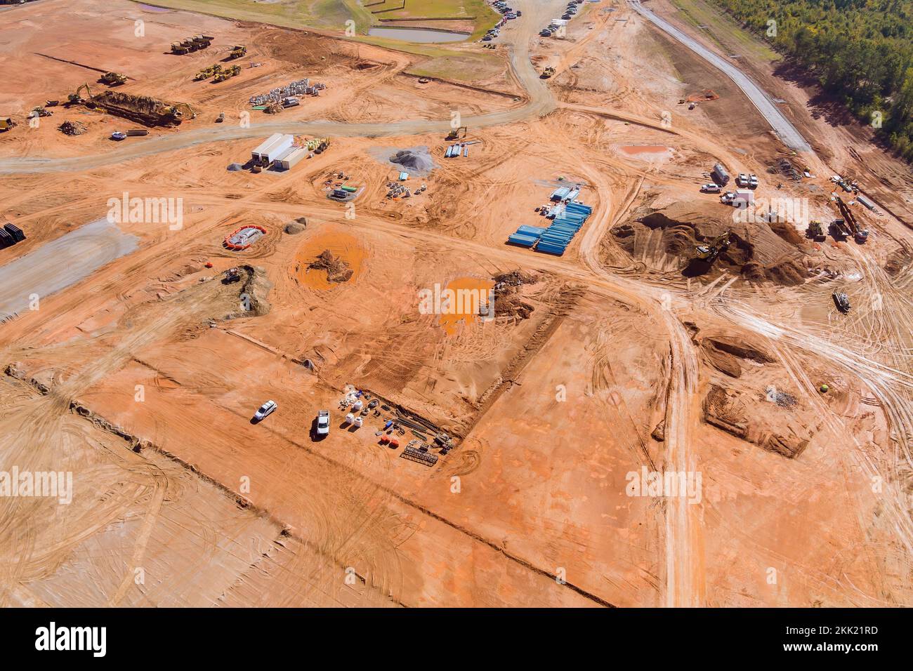 An aerial view of large construction site where earthmoving equipment ...