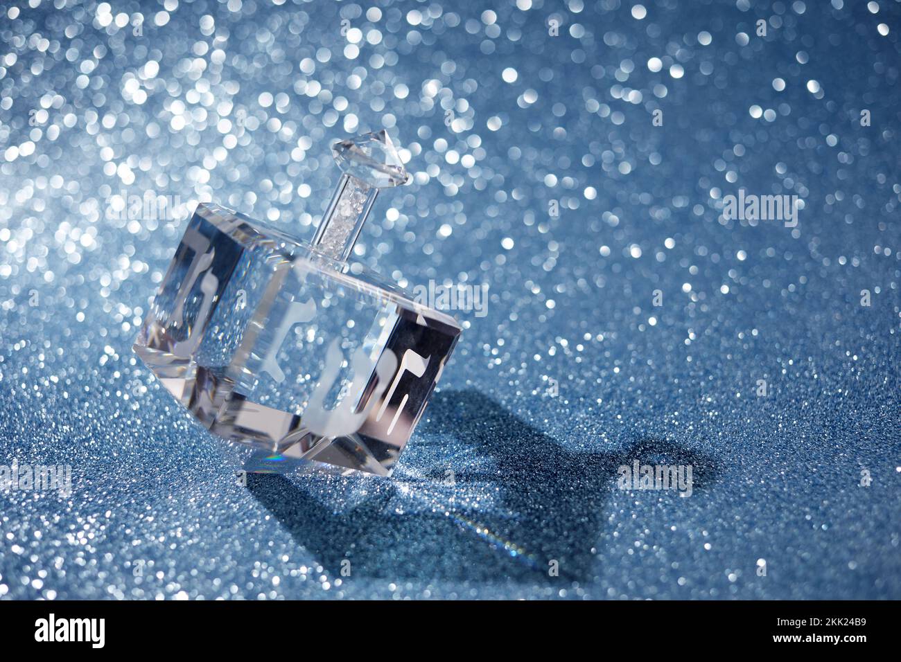 Hanukkah traditional dreidel with letters Gimel and Nun on shining blue ...