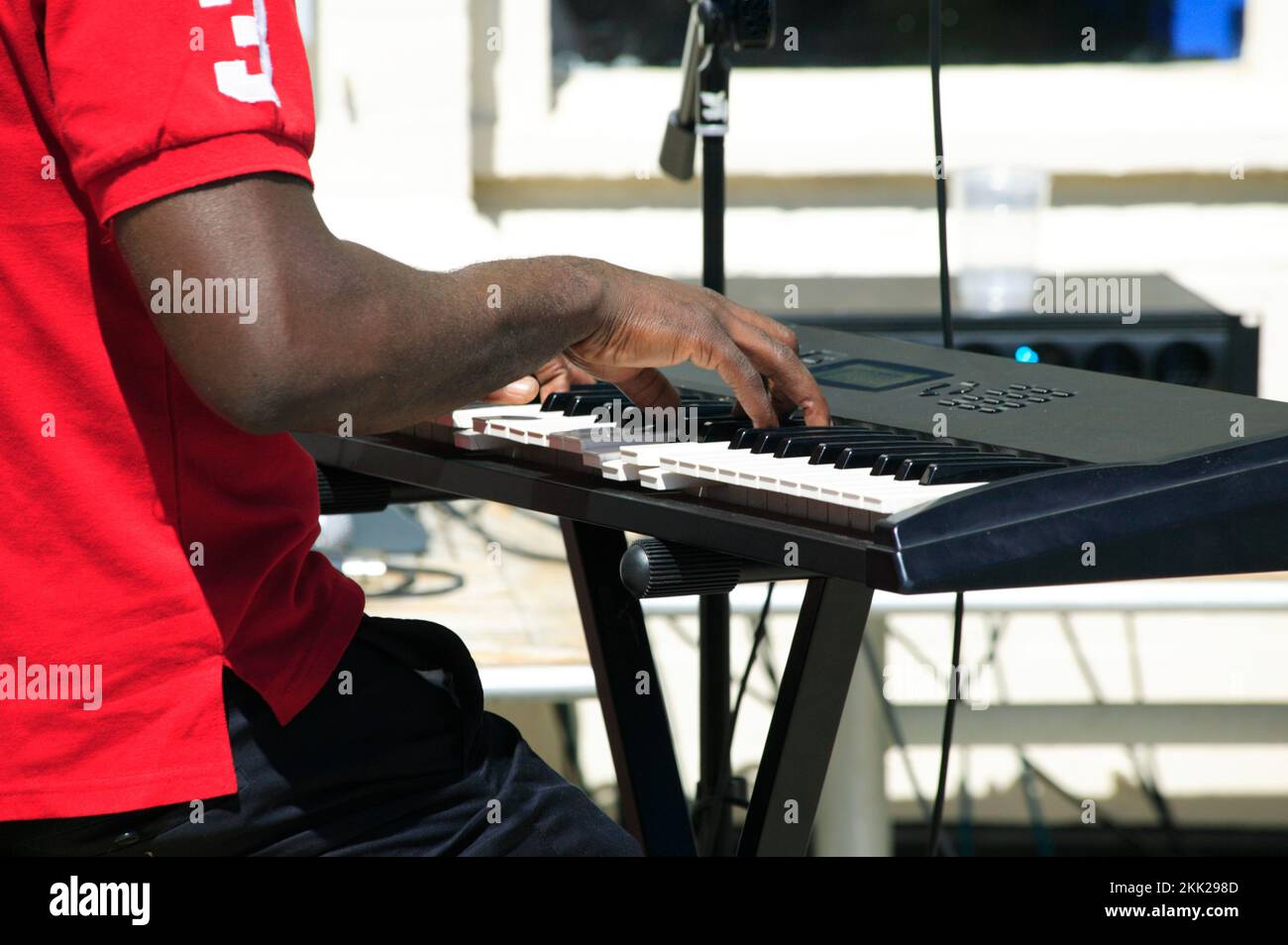 Synthesizer keyboard player at a live concert, playing a chord on piano ...