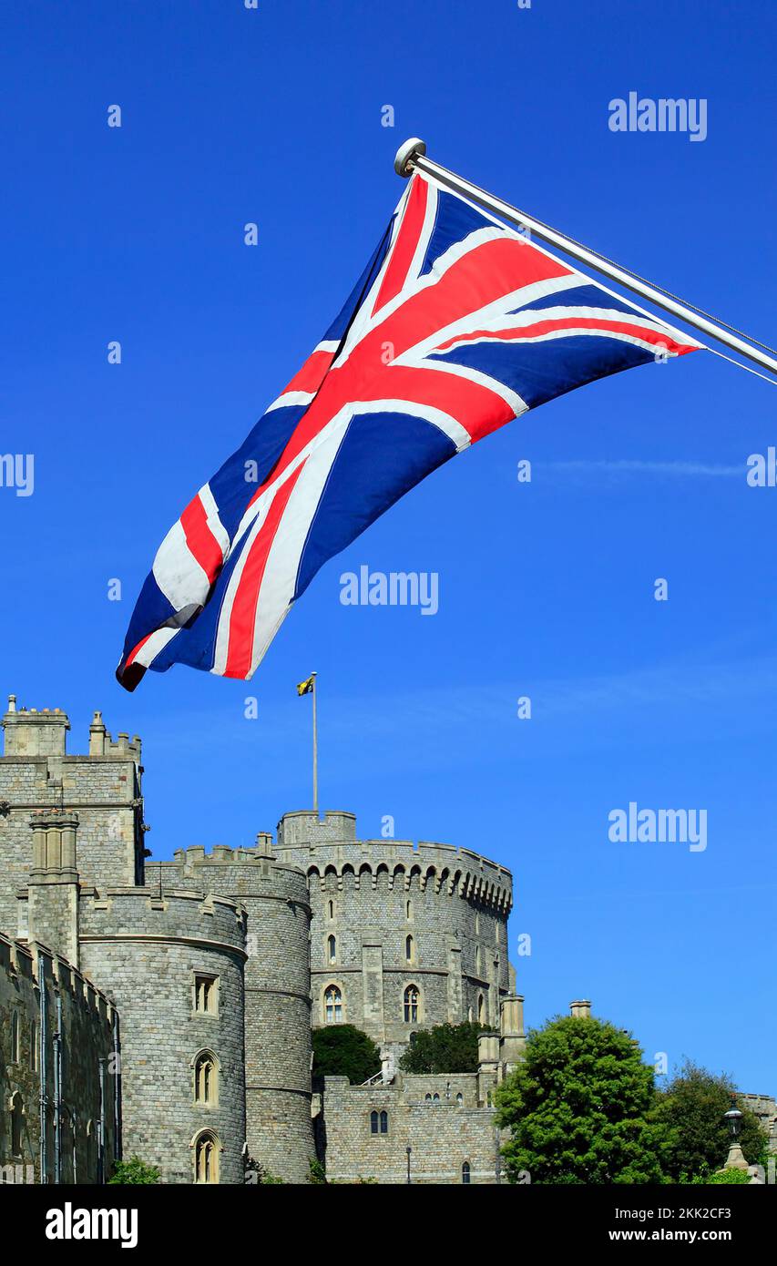 Windsor Castle with a Union Jack flying in the foreground. The castle ...