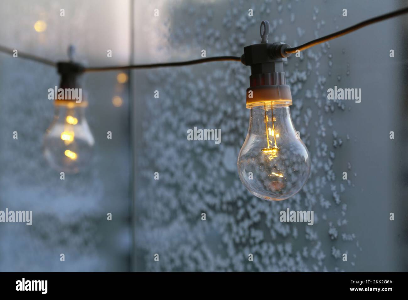 Decorative simple light bulb hanging on a balcony during a cold day ...