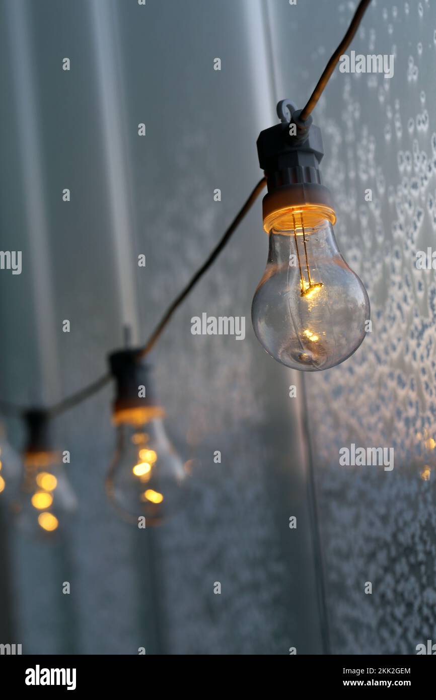 Decorative simple light bulb hanging on a balcony during a cold day ...