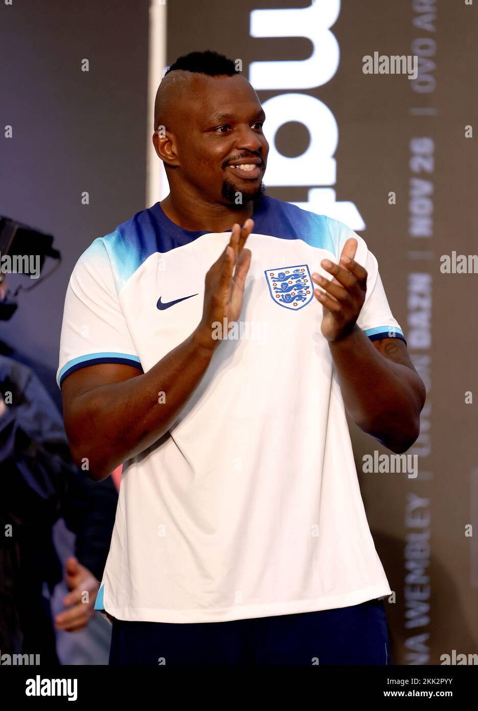 Dillian Whyte on stage wearing an England shirt before the weigh-in at ...