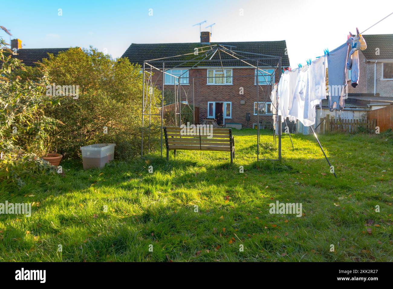 Looking back along a residential garden in autumn with long grass which ...