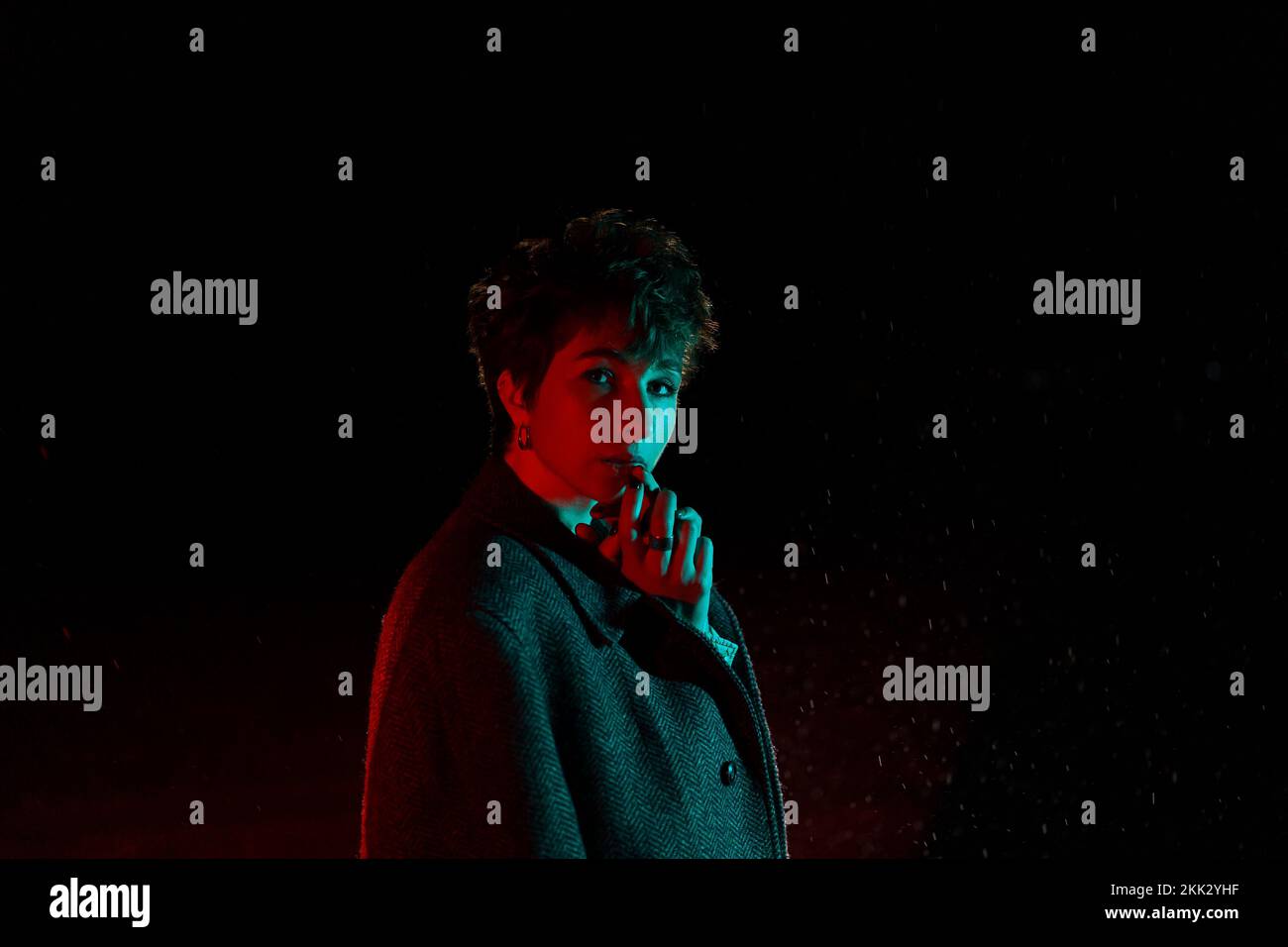 Frozen Caucasian woman as with coat draped over shoulders posing ...