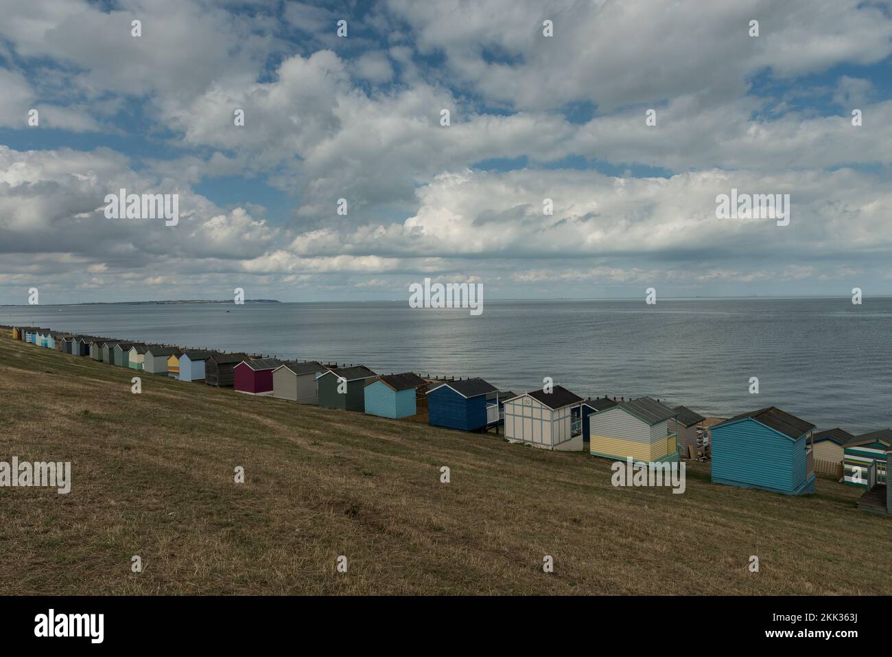 Lovely maintained beach huts on a clam lazy summers day at hightide ...