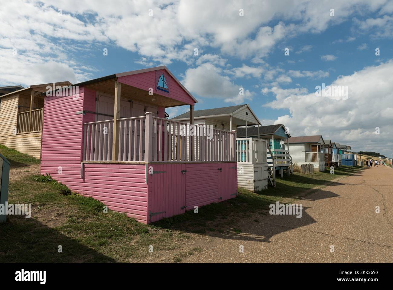 Lovely maintained beach huts on a clam lazy summers day at hightide ...
