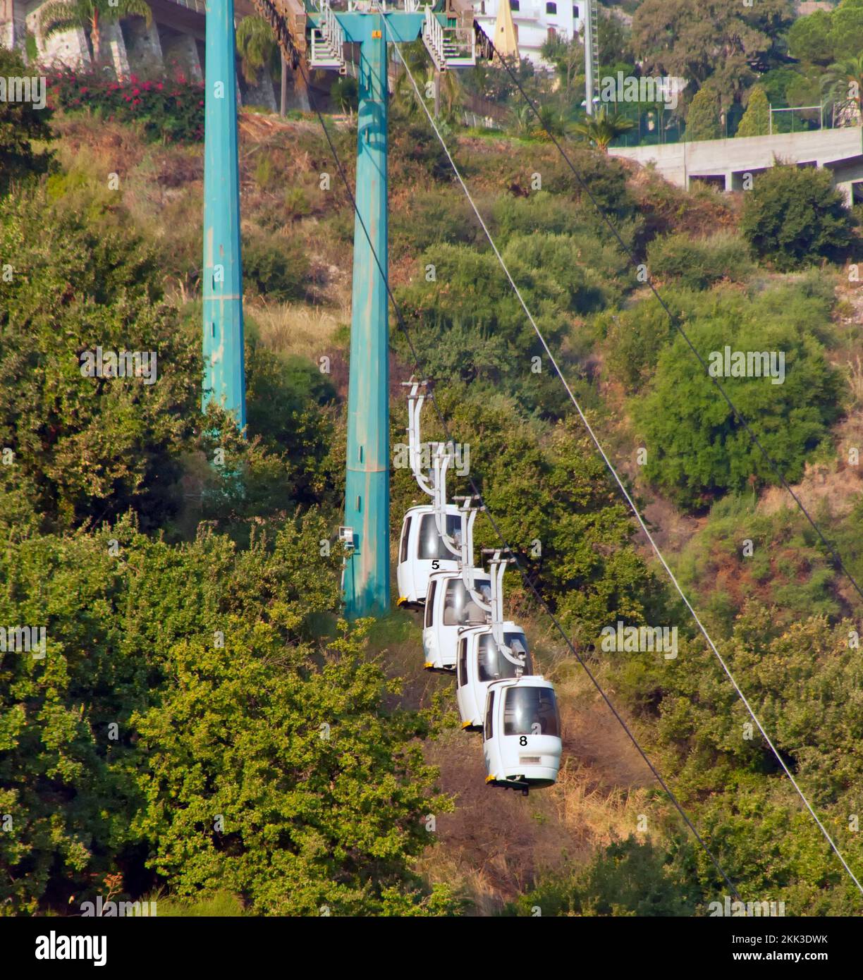 A line of cable cars ascending a green hill Stock Photo - Alamy