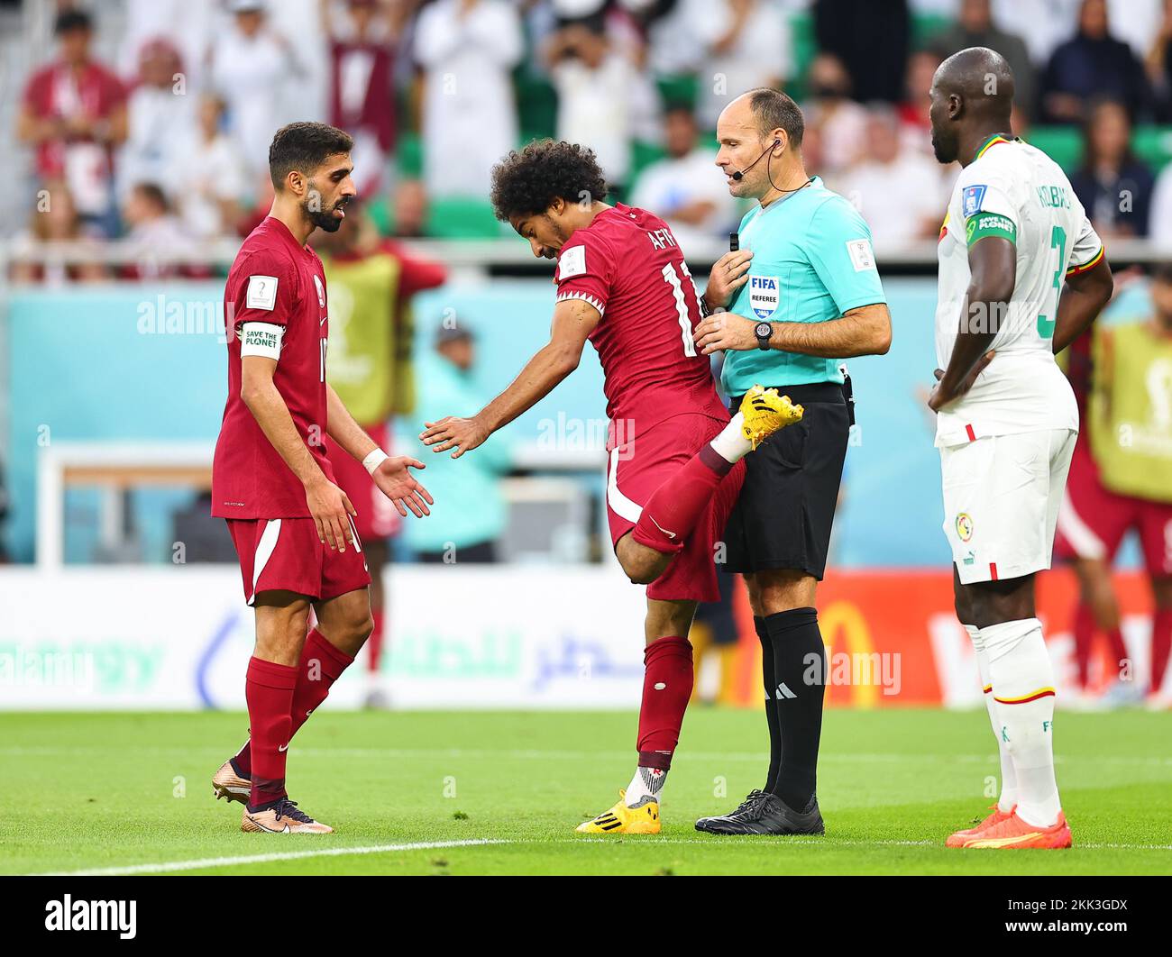 Doha, Qatar. 25th Nov, 2022. Akram Afif (2nd R) of Qatar communicates ...